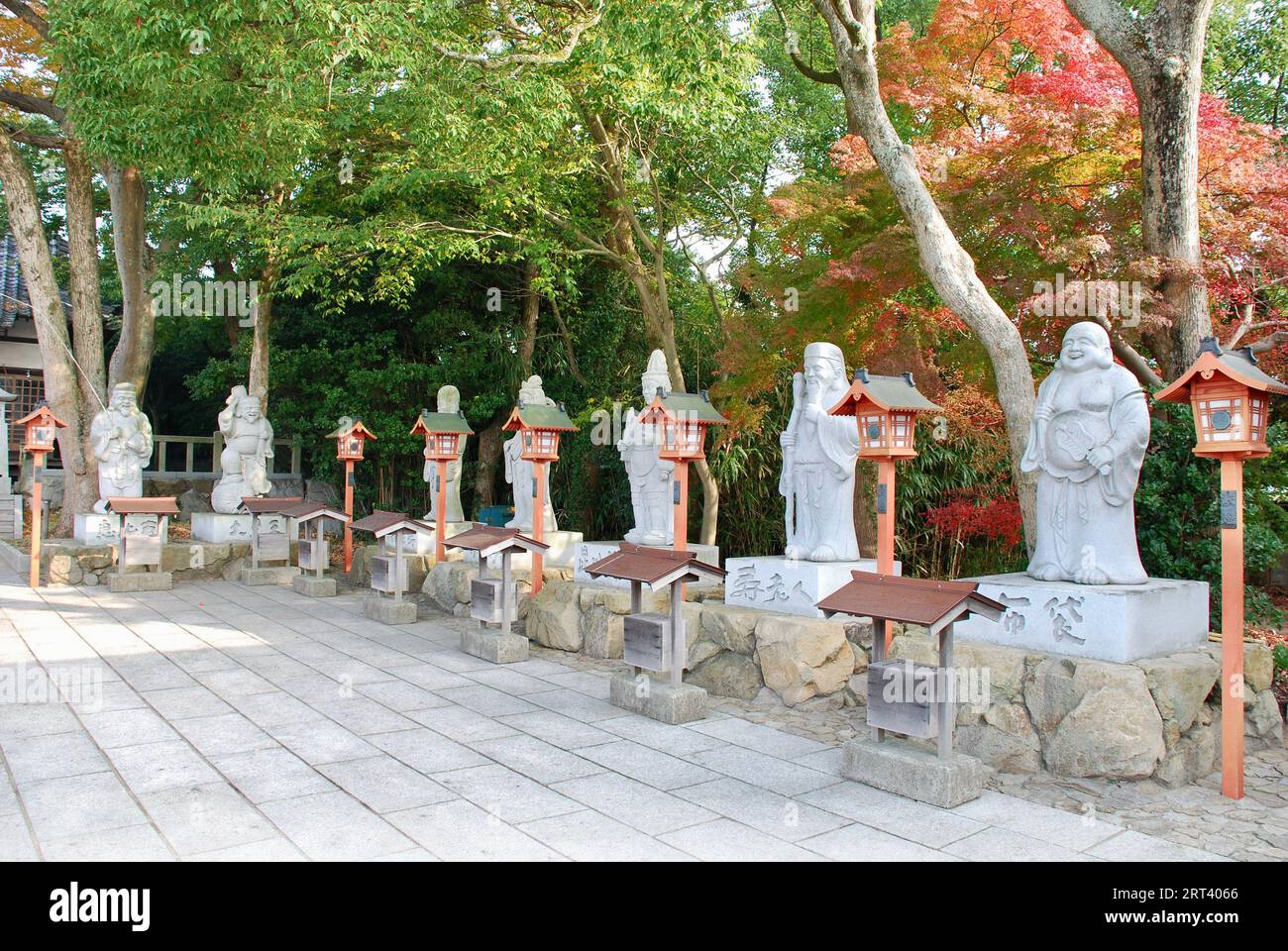 A stone wall featuring an array of ornately decorated Asian sculptures ...