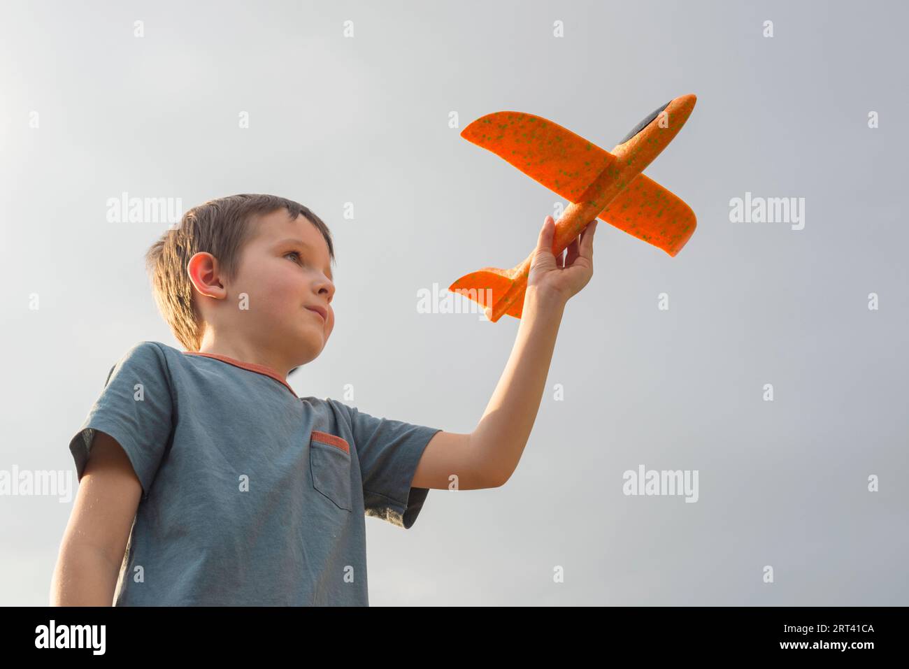 Little boy launches a toy plane into the air. Child launches a toy ...