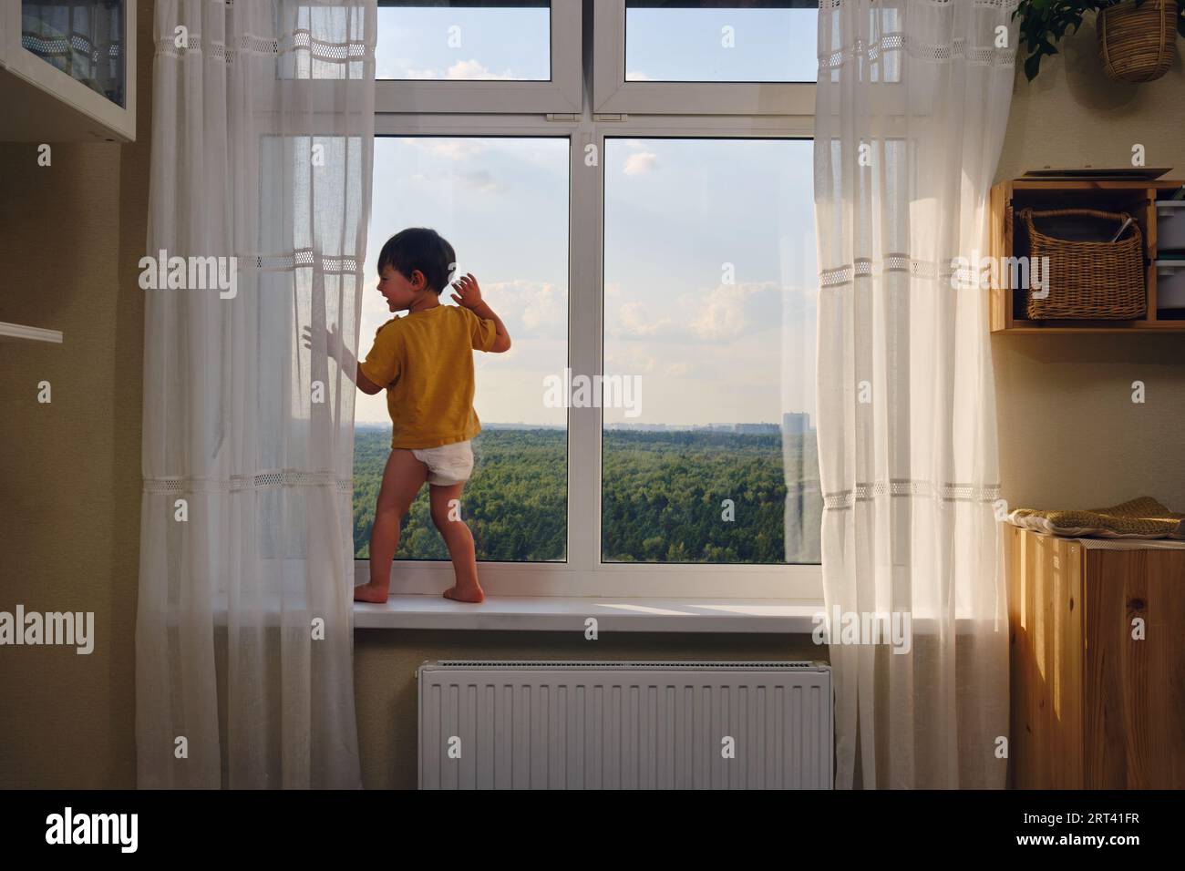 The child is alone by the window, lost in thought and risking their ...