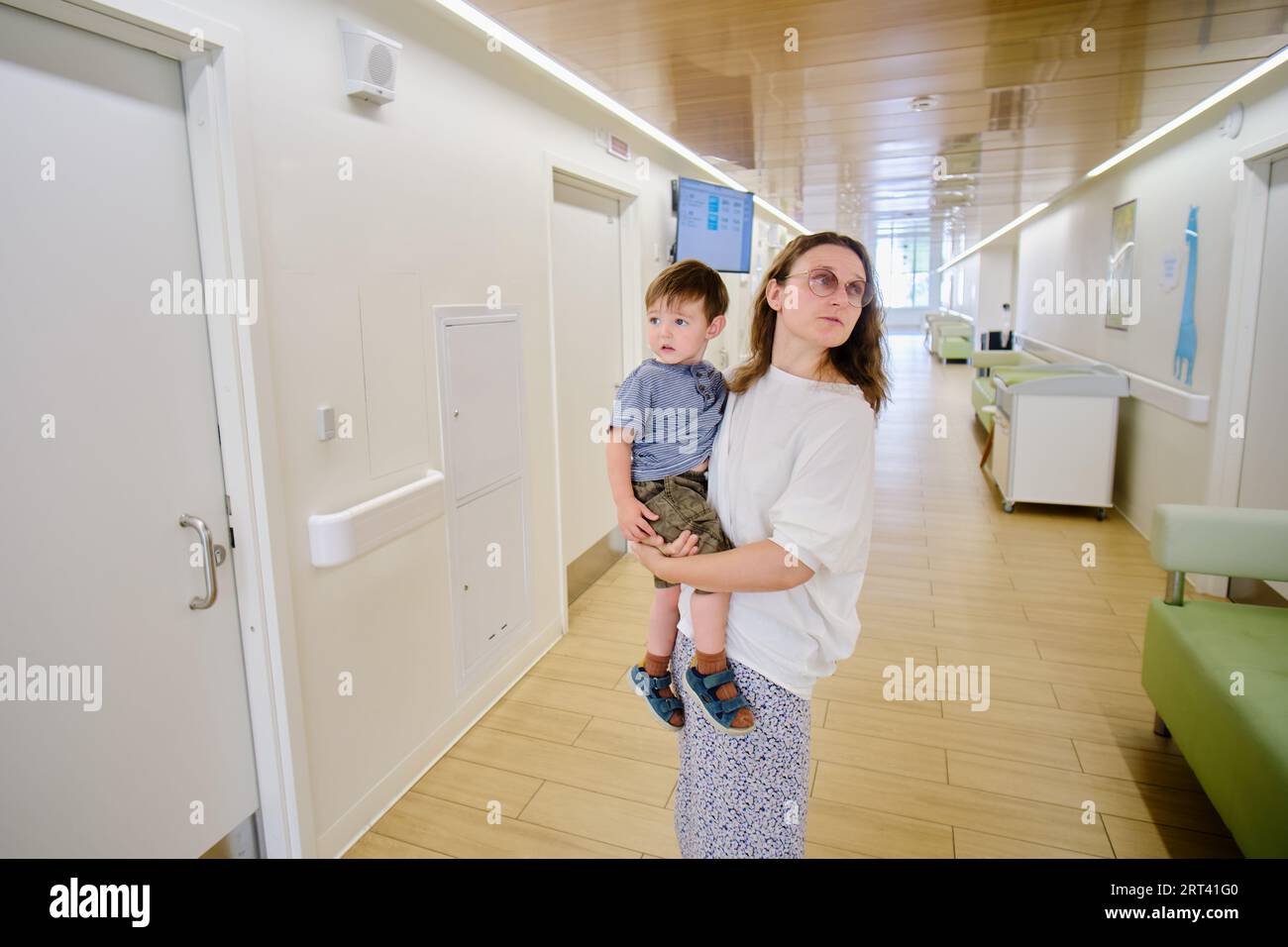 A woman and her child in the hospital corridor, waiting for their appointment with the doctor ...