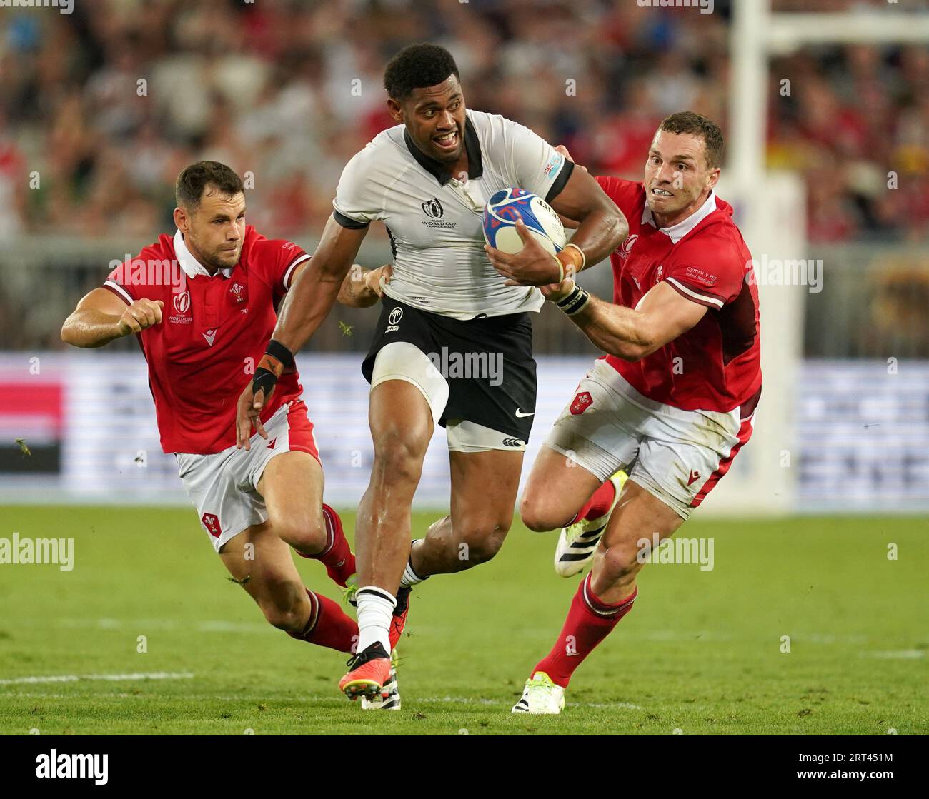 Fiji's Ilaisa Droasese with Wales' Tomos Williams (left) and George ...