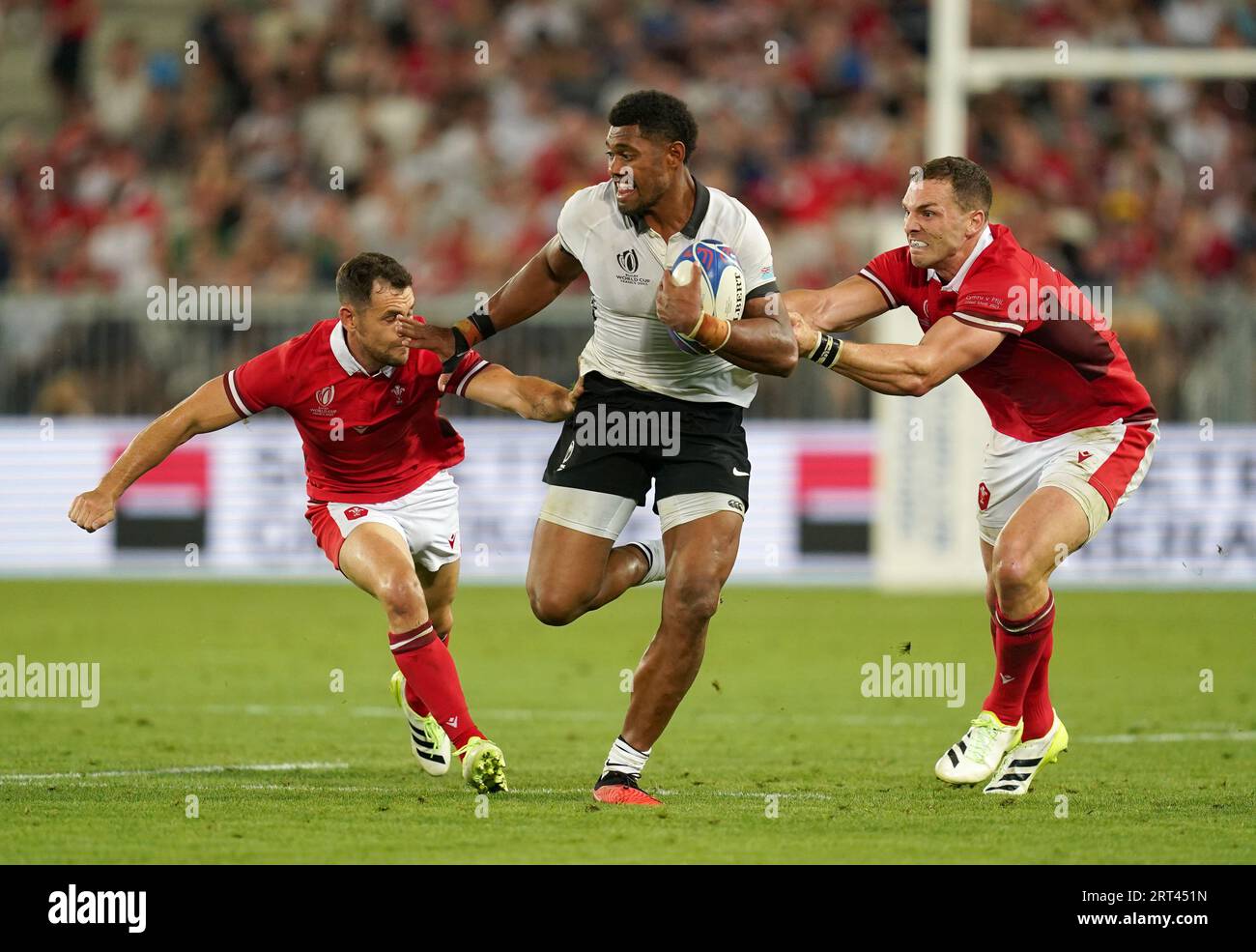 Fiji's Ilaisa Droasese with Wales' Tomos Williams (left) and George ...