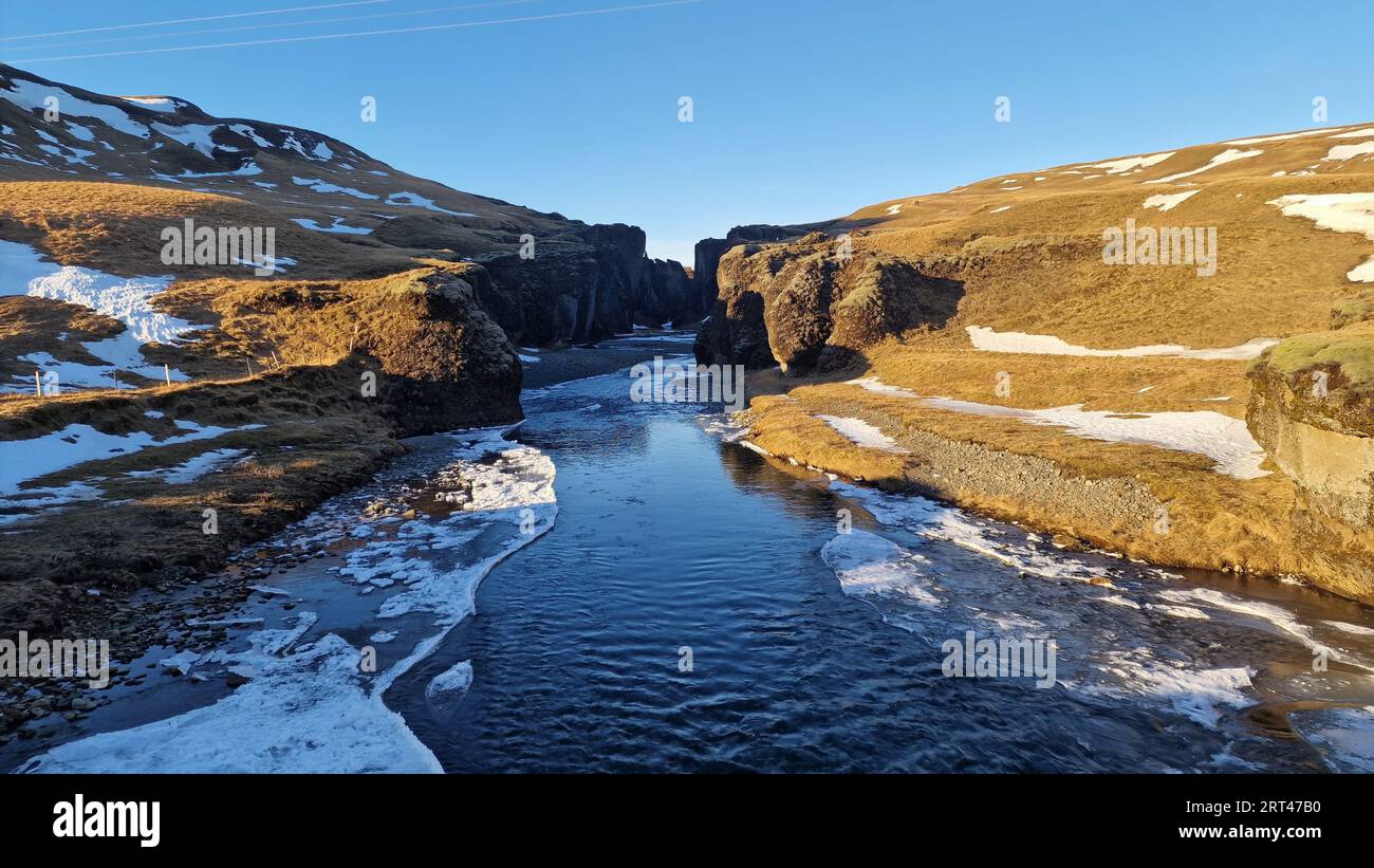 Icelandic canyon with frozen water stream flowing down between ...