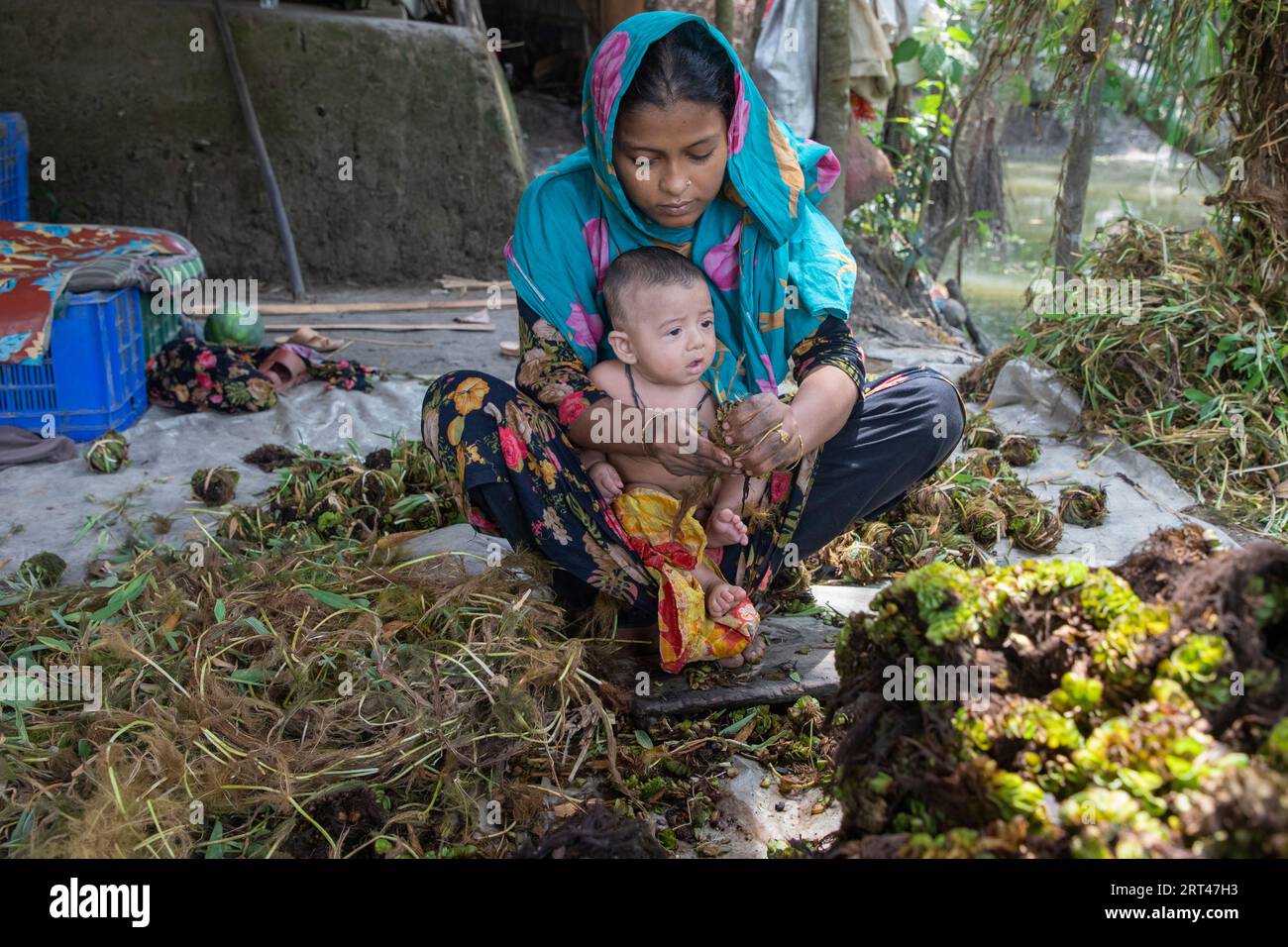A woman prepares seedling balls to be planted on their floating farm ...