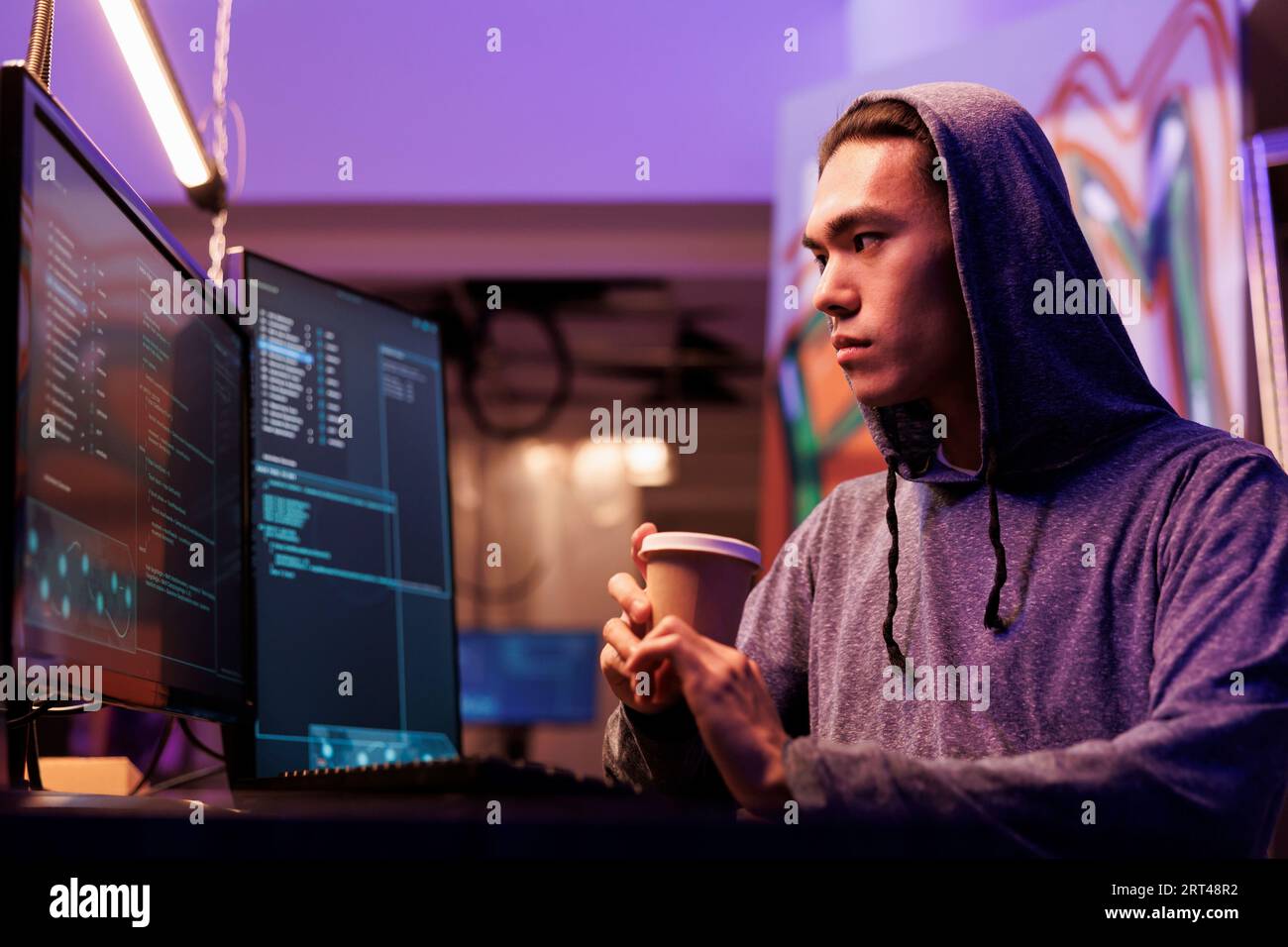 Asian hacker drinking coffee and doing ddos attack on website. Criminal ...