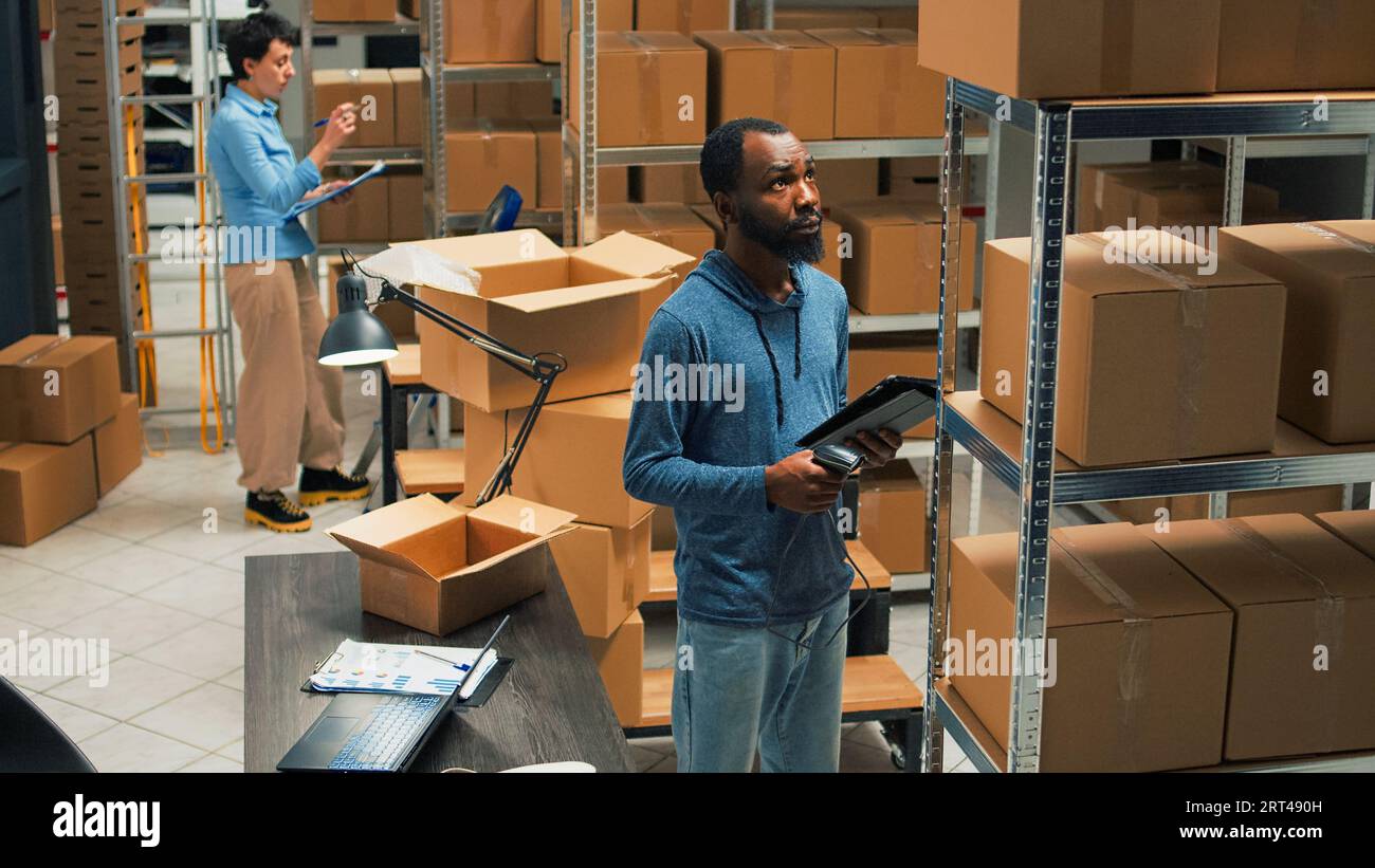 Small business owner scanning bar code on carton boxes, working on ...