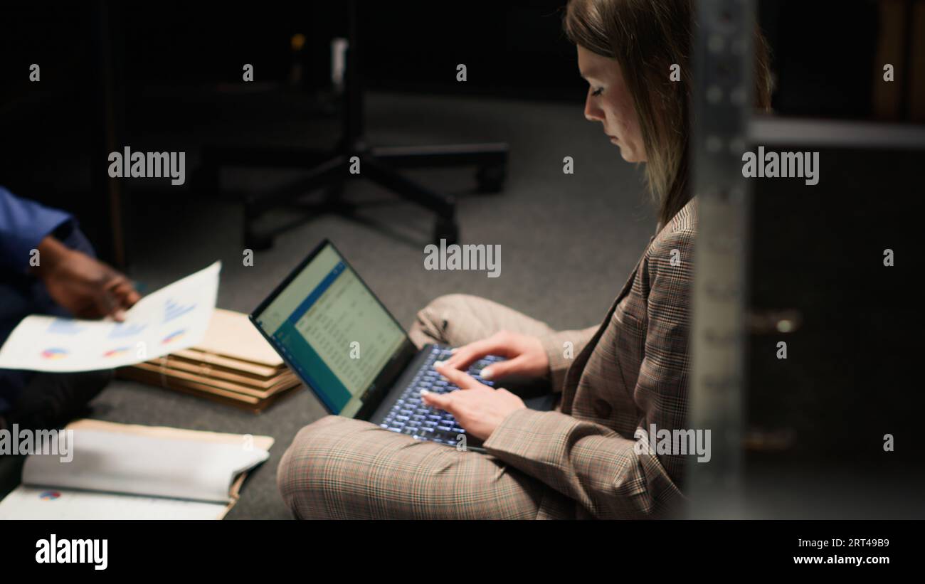 Focus on female private detective diligently using laptop in incident ...