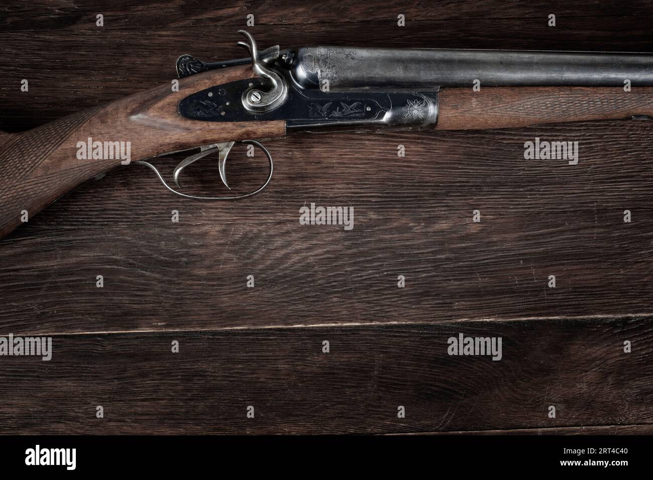 Antique 12-gauge break-action smooth-bored shotgun on wooden table ...
