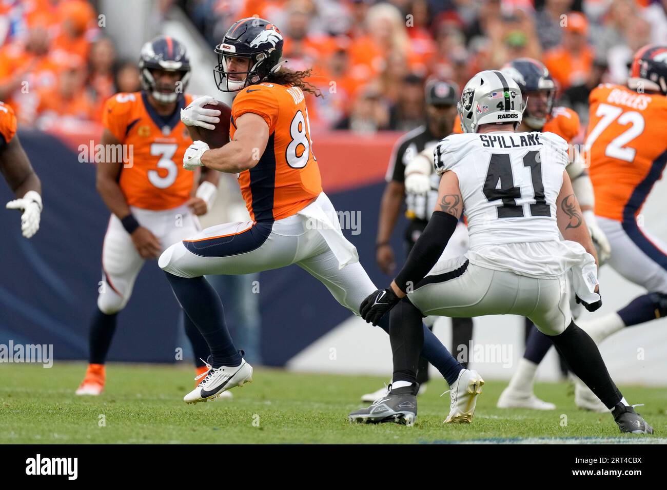 Denver Broncos tight end Greg Dulcich, left, runs with the ball after ...