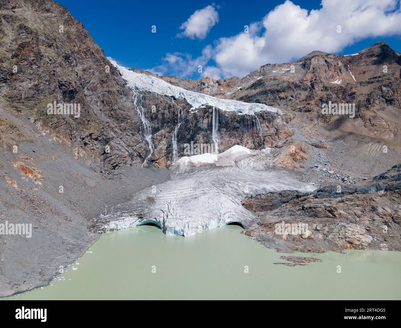 Aerial of melting glacier in the mountain, waterfall, lake, ice crevasses. Fellaria Glacier ...