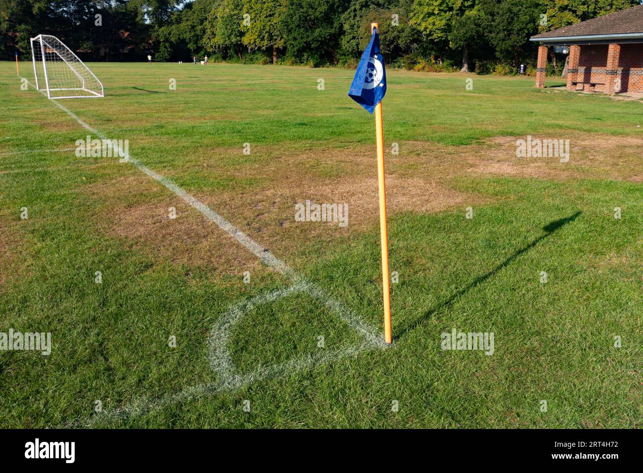 A corner flag and pitch markings at the corner of a football or soccer pitch in England, UK ...
