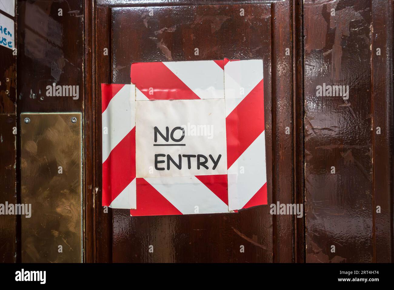 A no entry notice taped to a wooden door informing people that they are ...