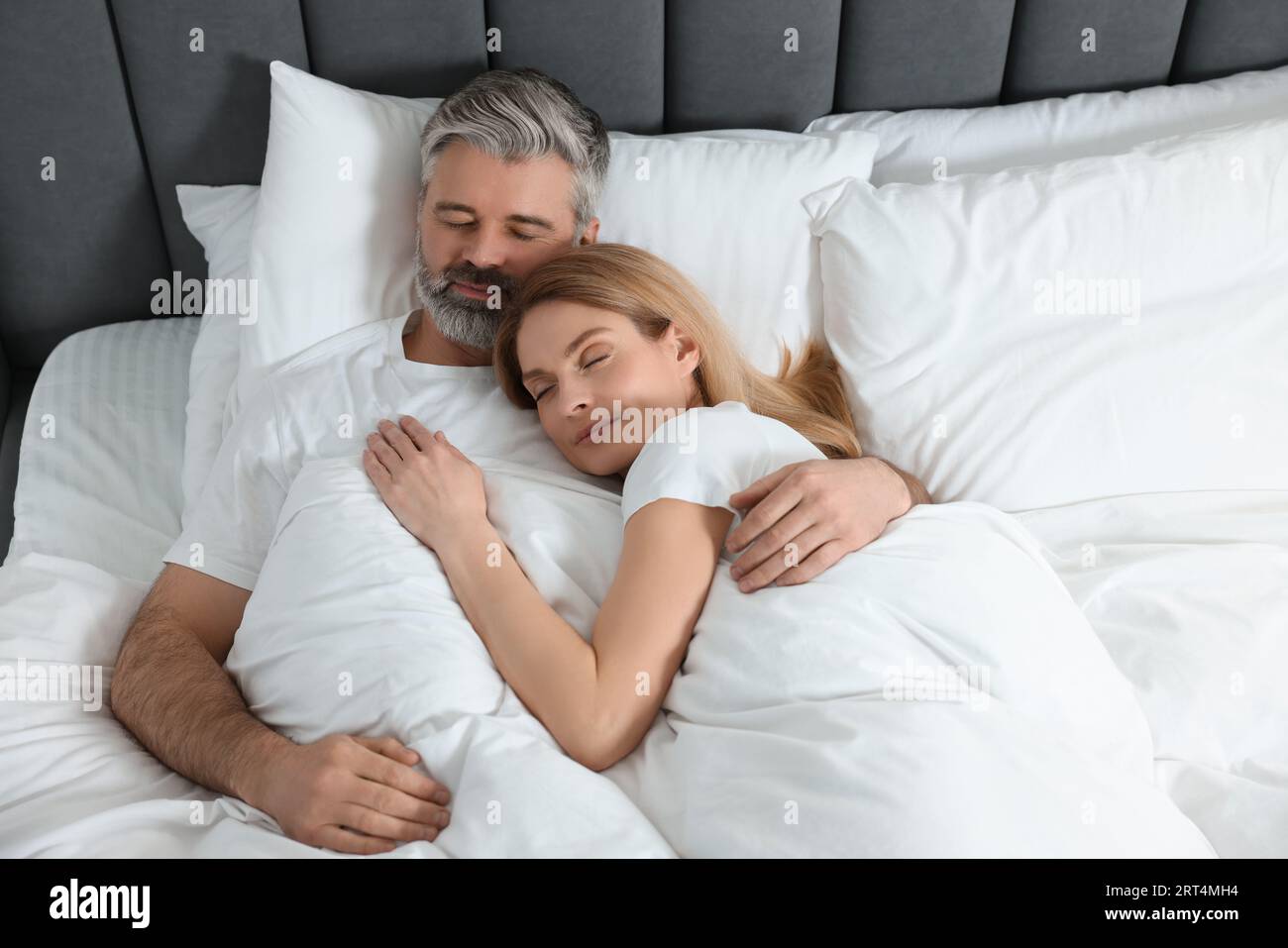 Lovely mature couple sleeping together in bed at home, above view Stock ...