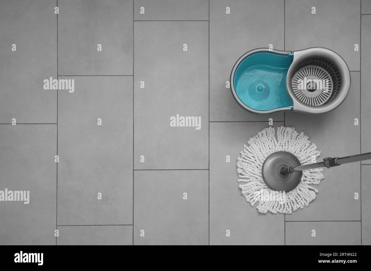 String mop and bucket on grey tiled floor, top view. Space for text ...