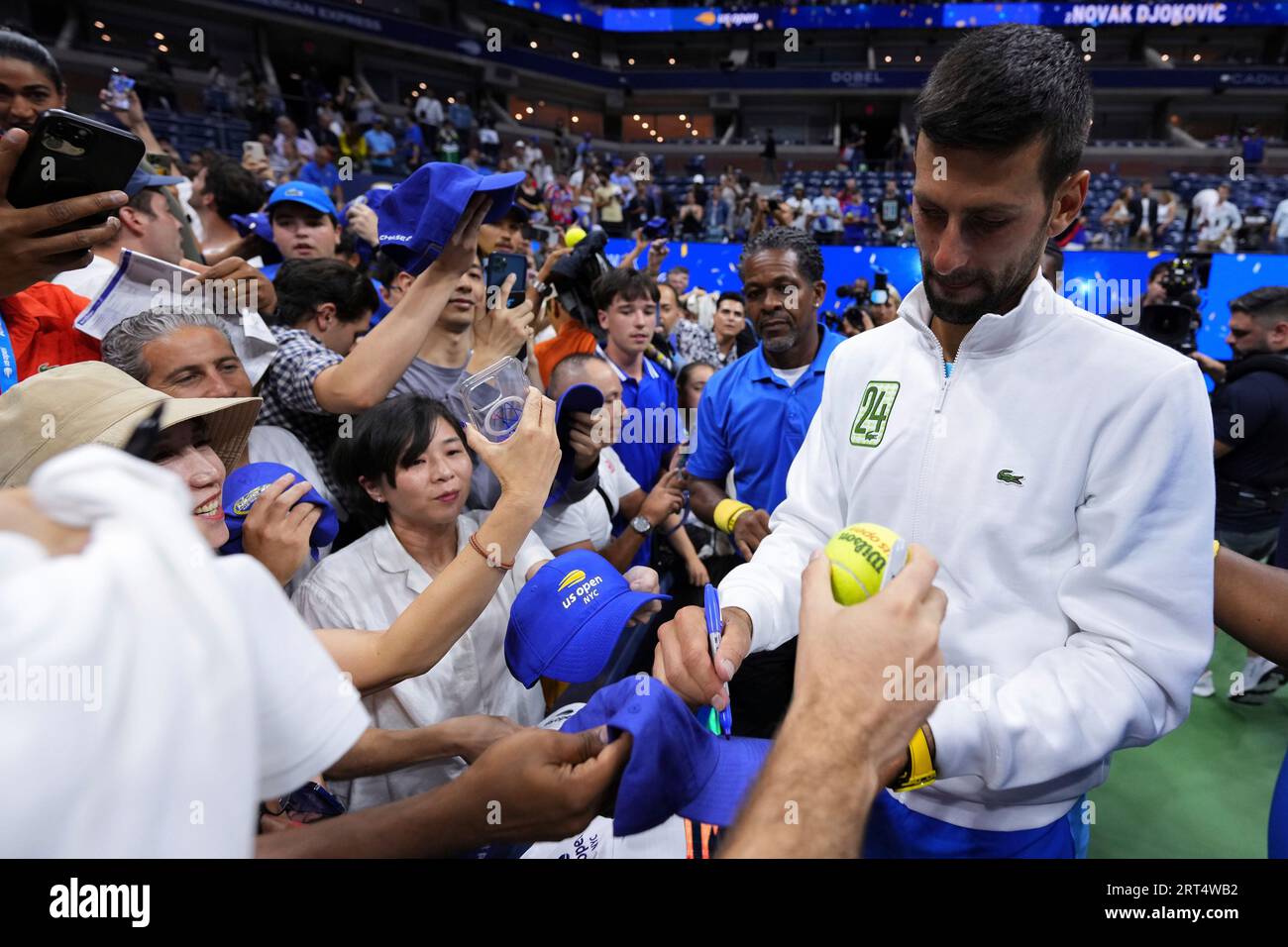 Novak Djokovic signs autographs for fans after winning a men's singles ...