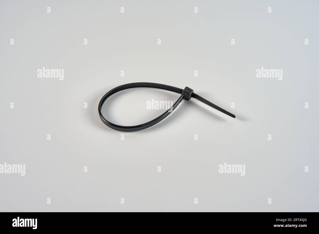 One used zip tie on a white background Stock Photo - Alamy