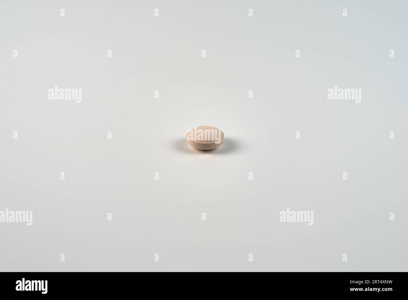 One pill on a white background Stock Photo - Alamy