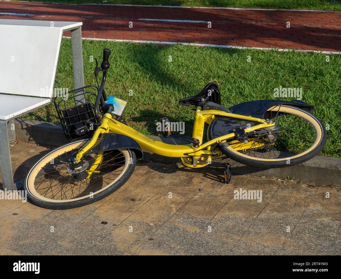Overturned bike. A yellow bicycle abandoned by a bench. The concept of ...