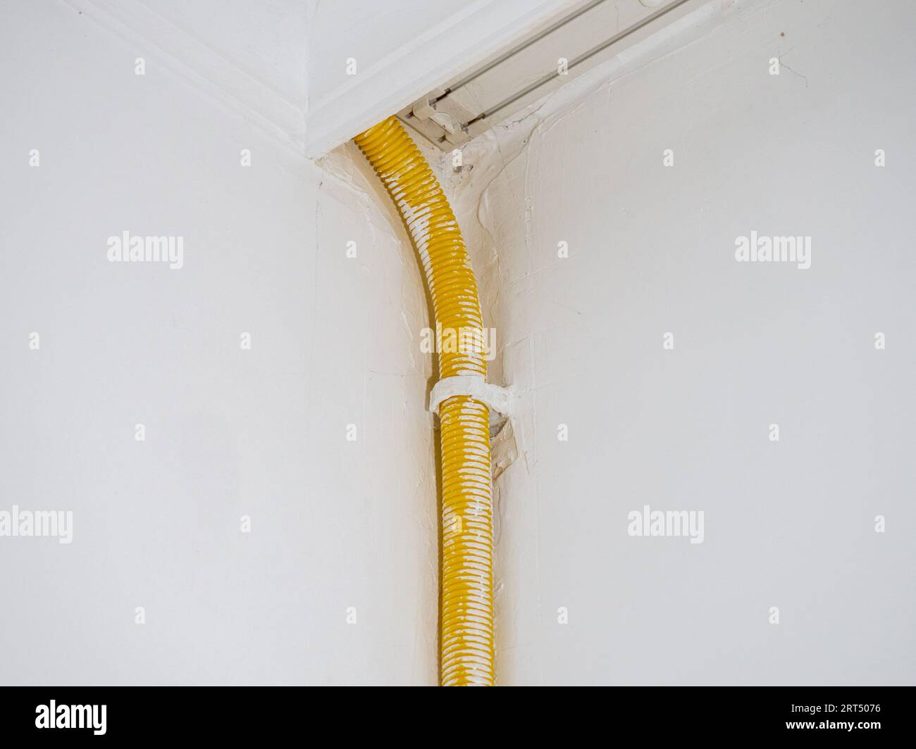 Spiral pipe for the cable from a home refrigerator. Yellow pipe in the ...