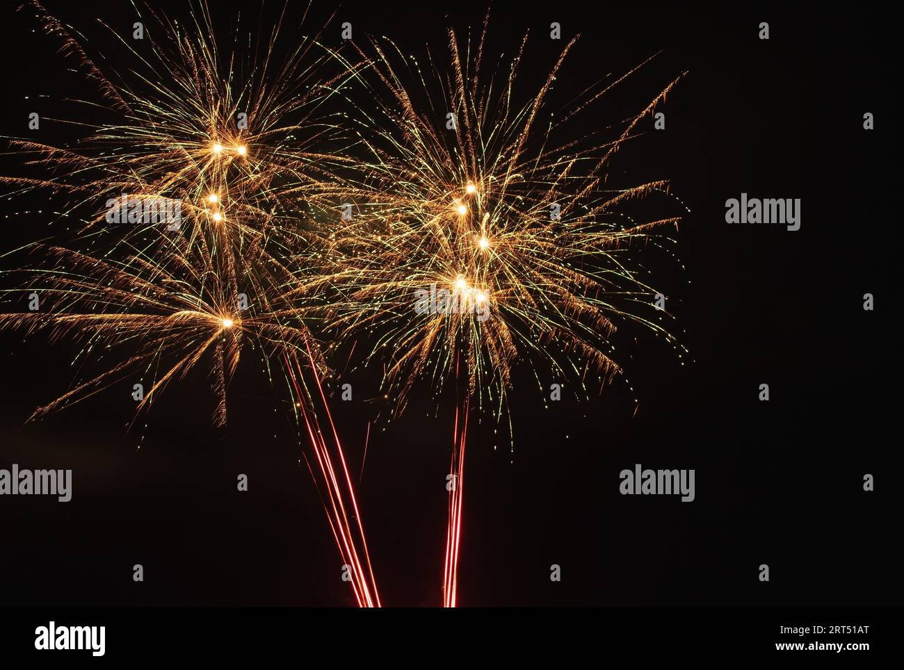 celebrating multiple yellow green and red colorful fireworks at night ...