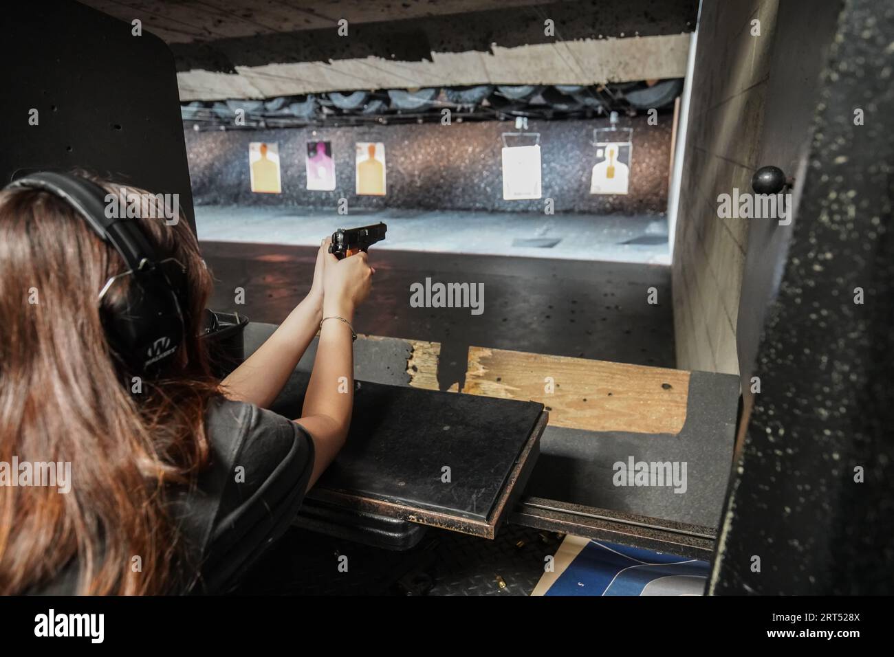 A lady holds a pistol during the gun training. Even though there are ...