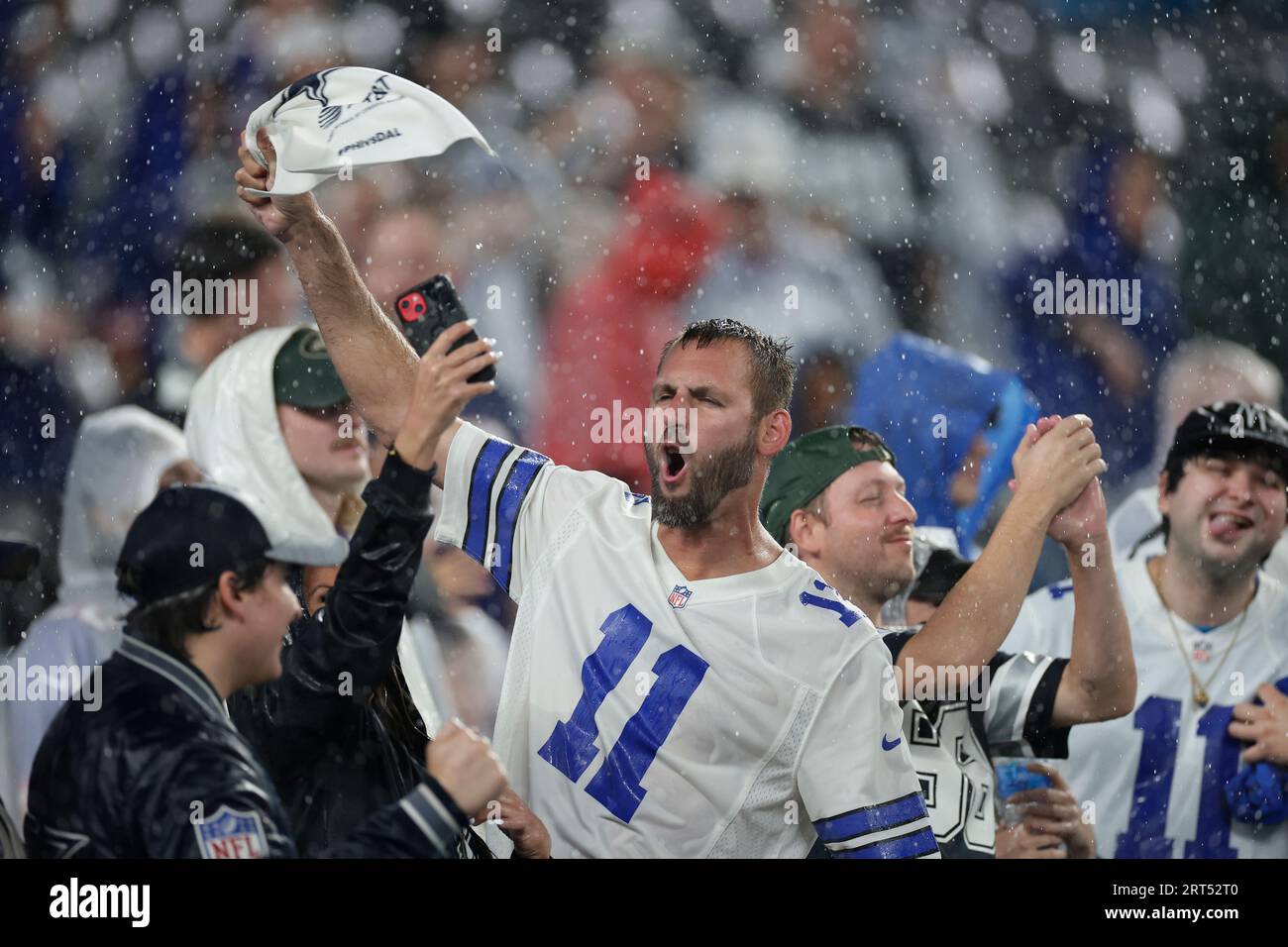 A Dallas Cowboys fan celebrates in the rain during the second half of ...