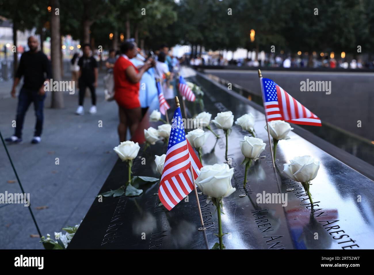 Flowers and US flags are laid on one of the North Pool panels at World ...