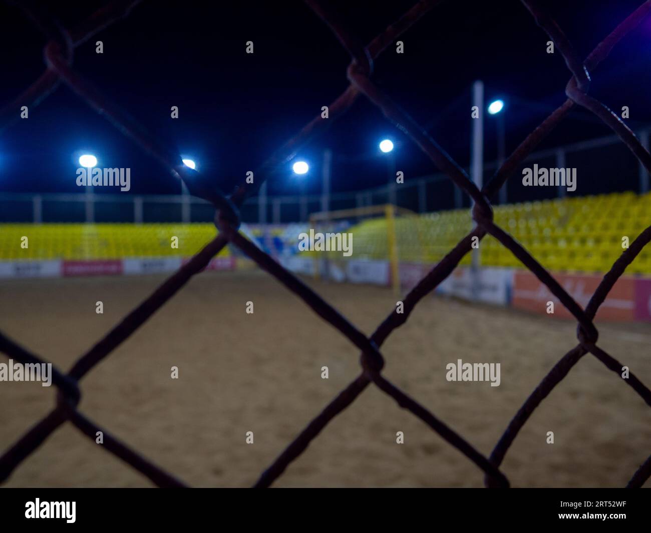 Beach soccer field through the fence mesh. Sand play concept ...