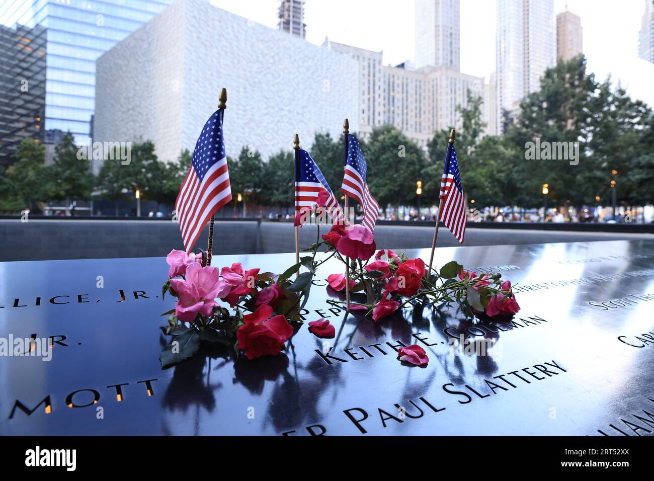 Flowers and US flags are laid on one of the North Pool panels at World ...
