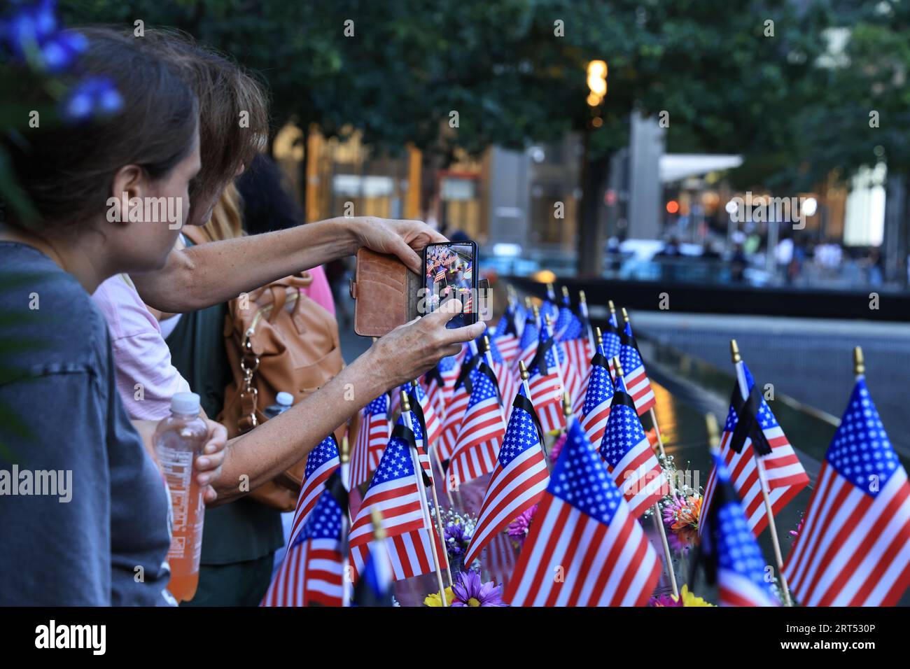 Flowers and US flags are laid on one of the South Pool panels at World ...