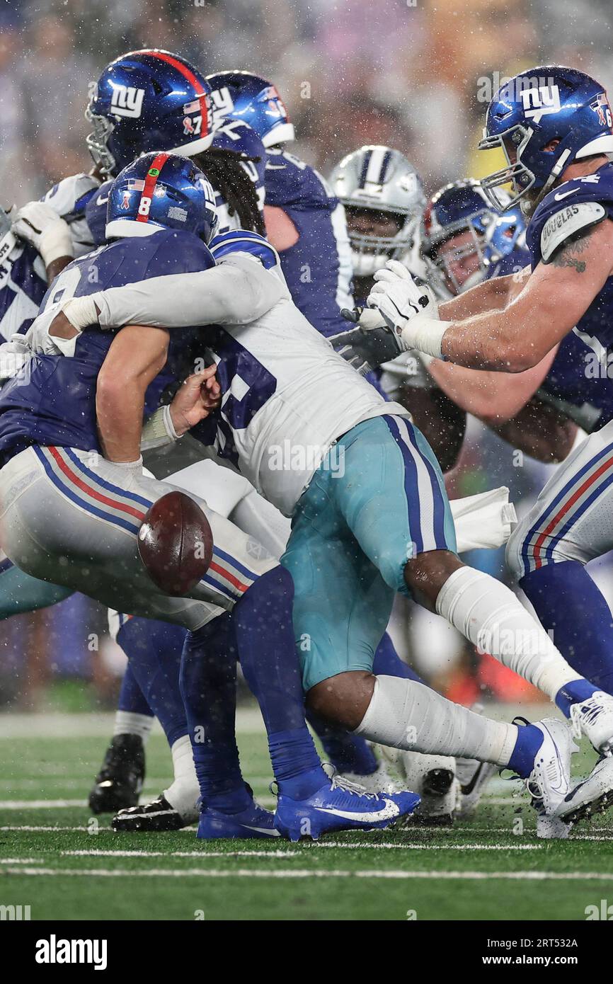 New York Giants quarterback Daniel Jones, left, fumbles the ball as he ...