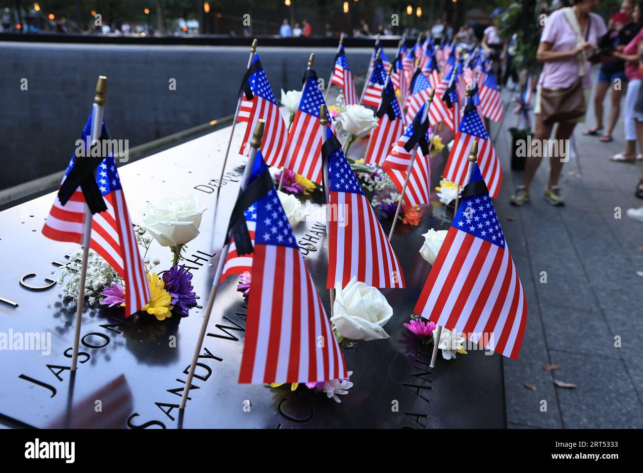 Flowers and US flags are laid on one of the South Pool panels at World ...