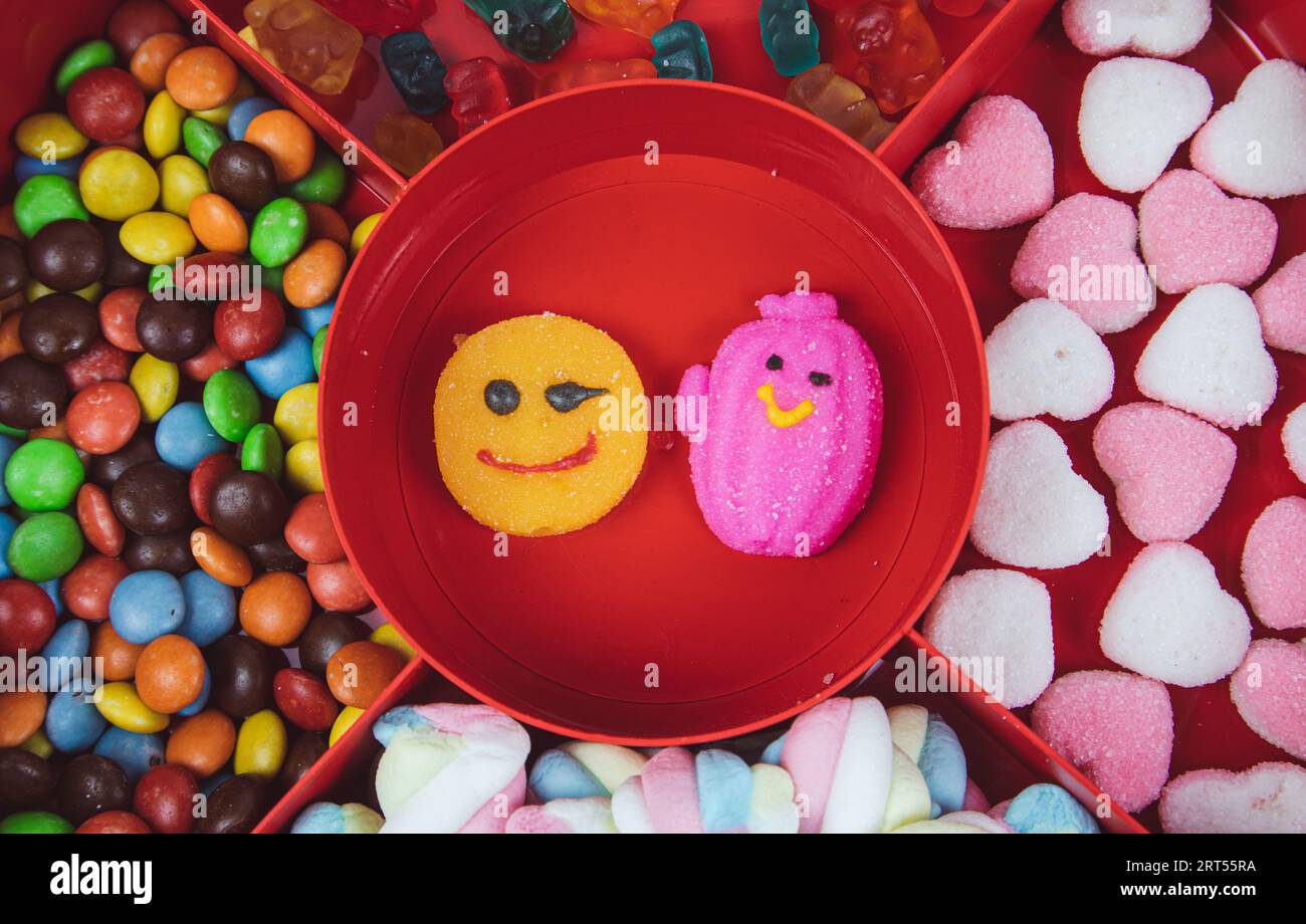 Set of different tasty candies in a red candy box on red background ...