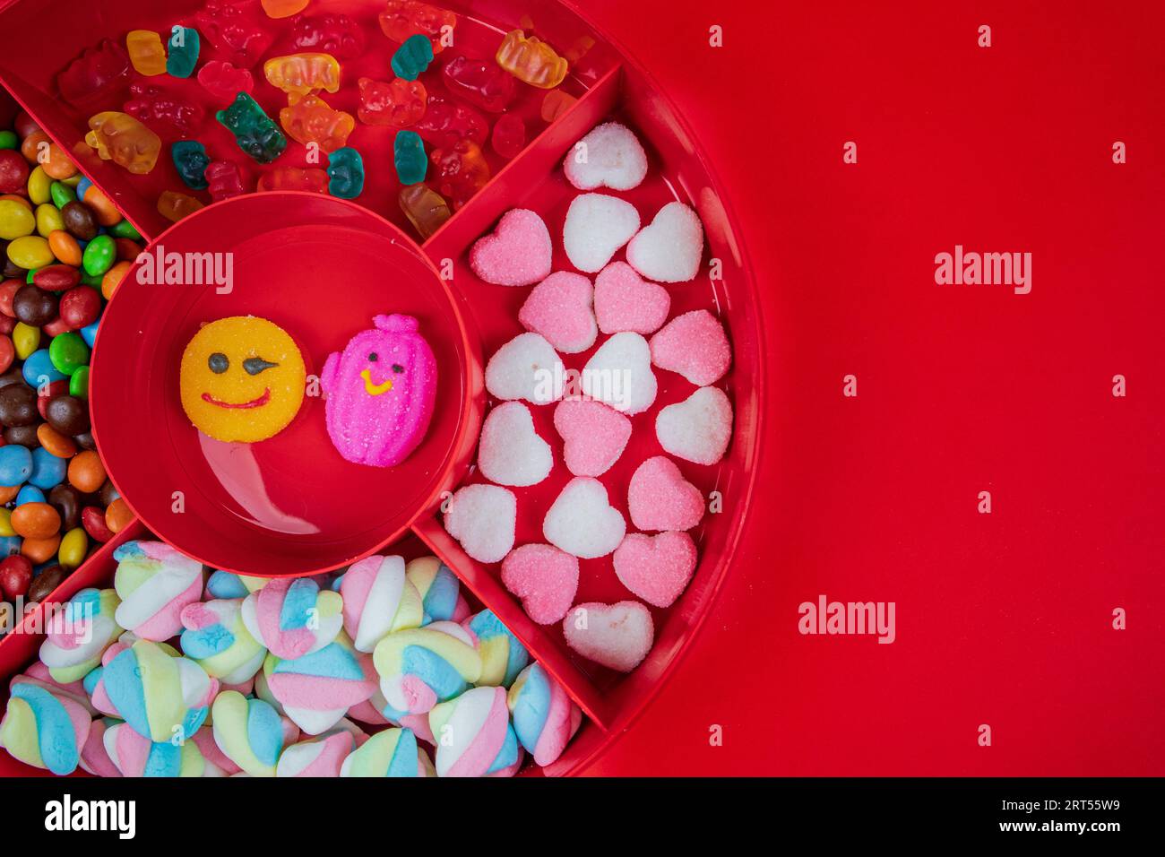 Set of different tasty candies in a red candy box on red background ...