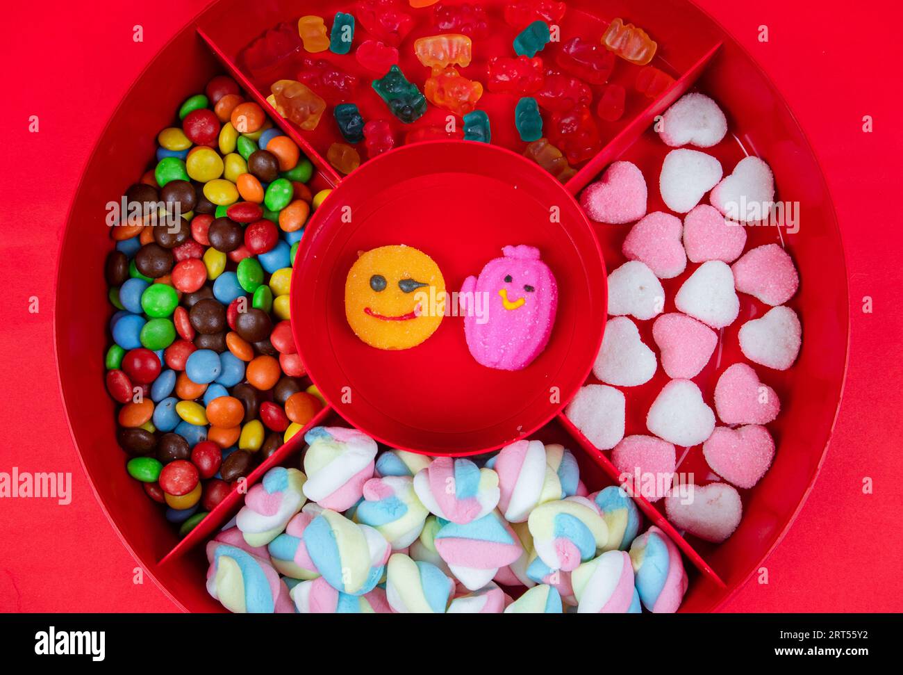 Set of different tasty candies in a red candy box on red background ...