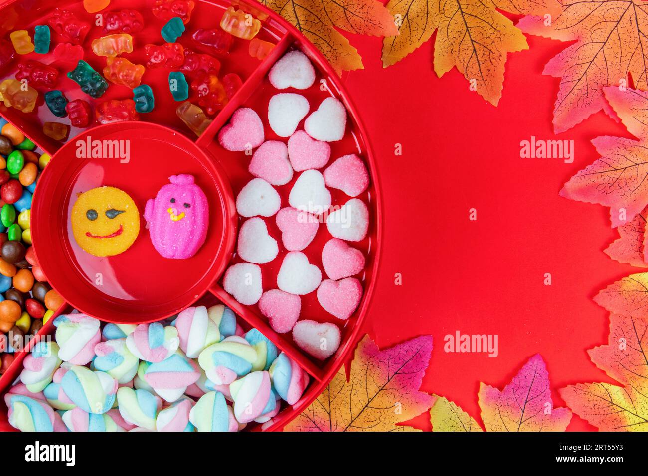 Set of different tasty candies in a red candy box on red background ...