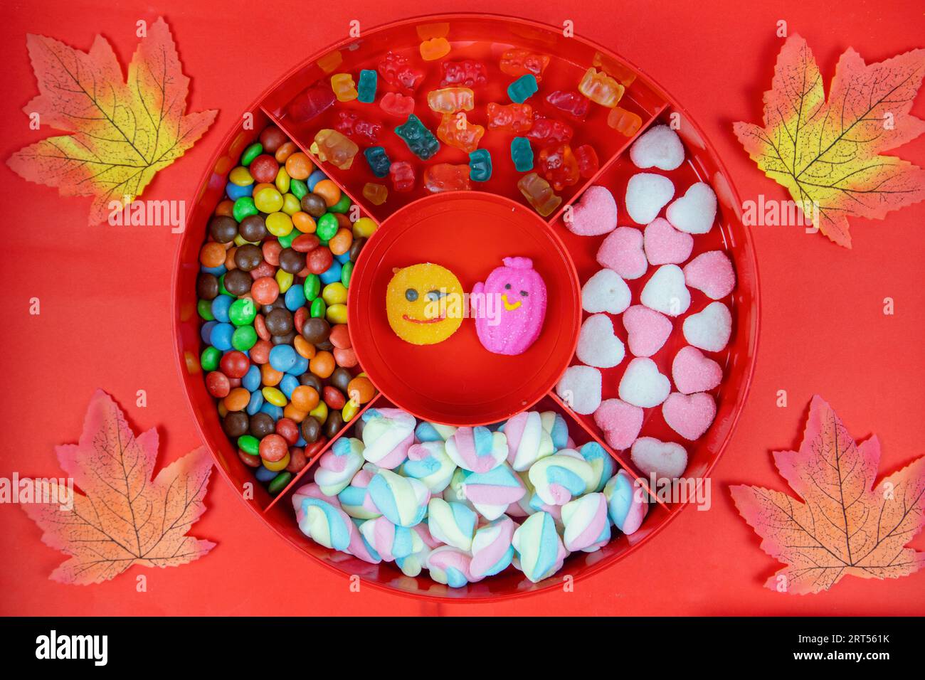 Set of different tasty candies in a red candy box on red background ...