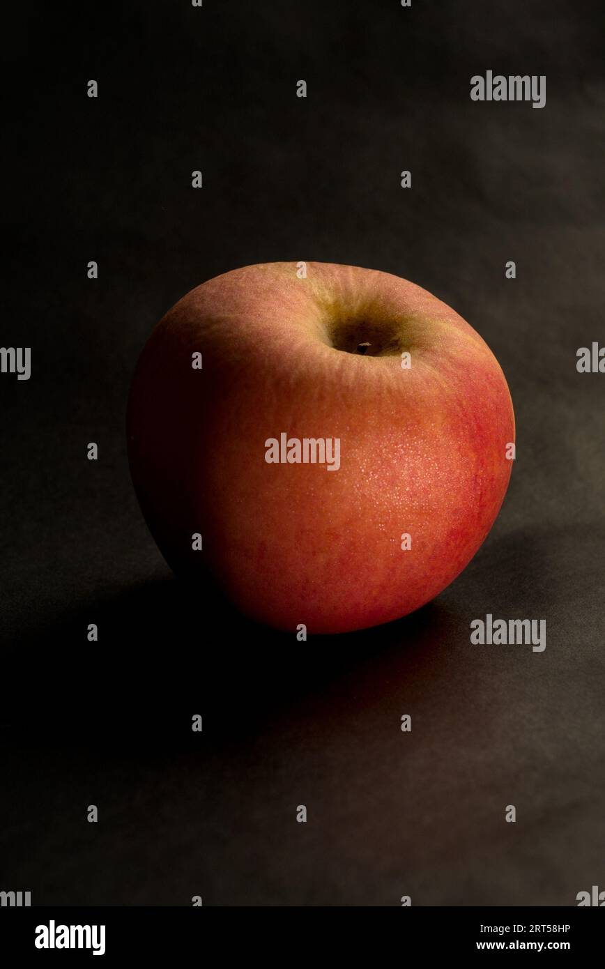A vertical closeup of a red apple on a dark background Stock Photo - Alamy