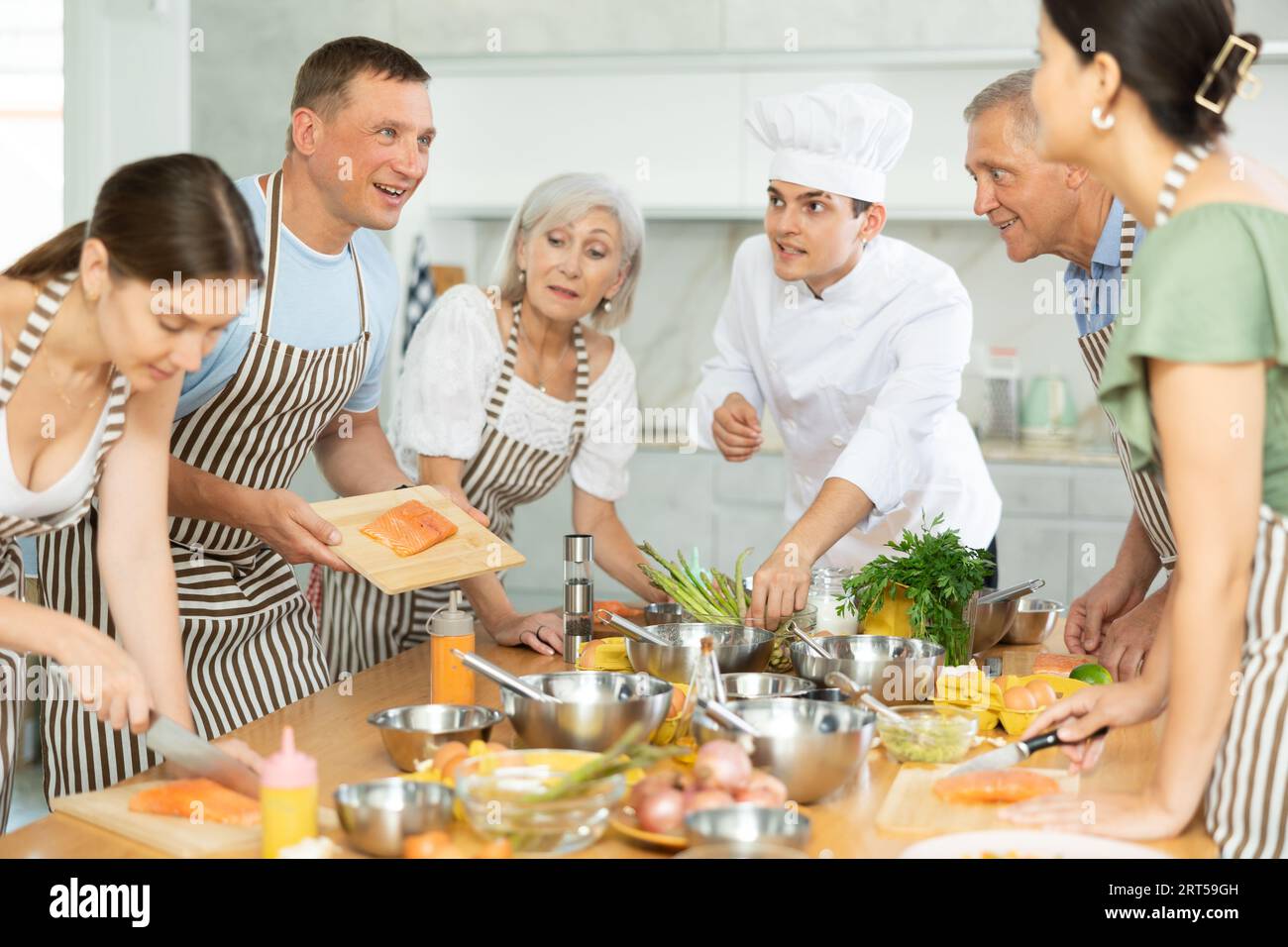 Young guy cook teaches to cook group of people Stock Photo - Alamy