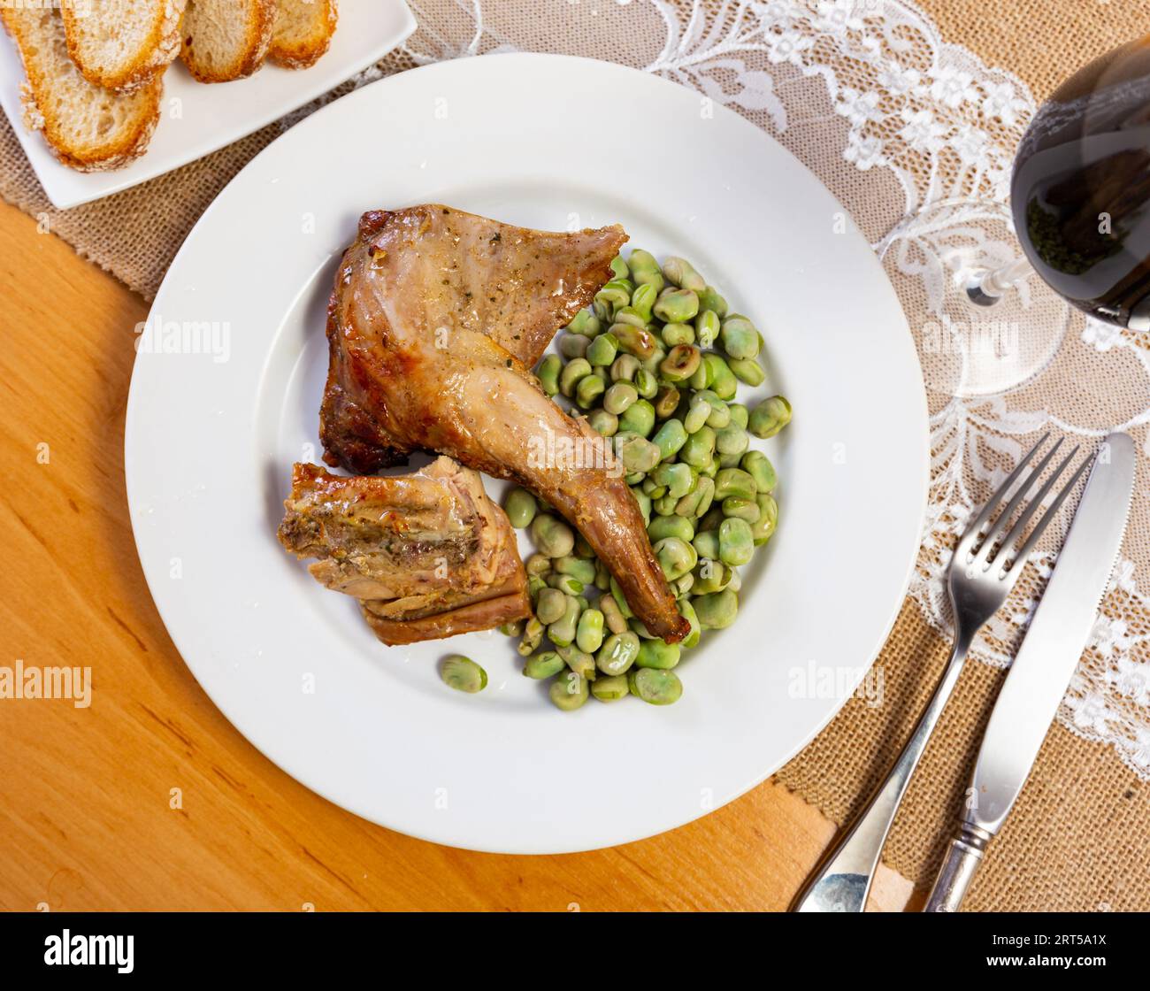 Oven-baked rabbit leg with braised beans in bowl, top view Stock Photo ...