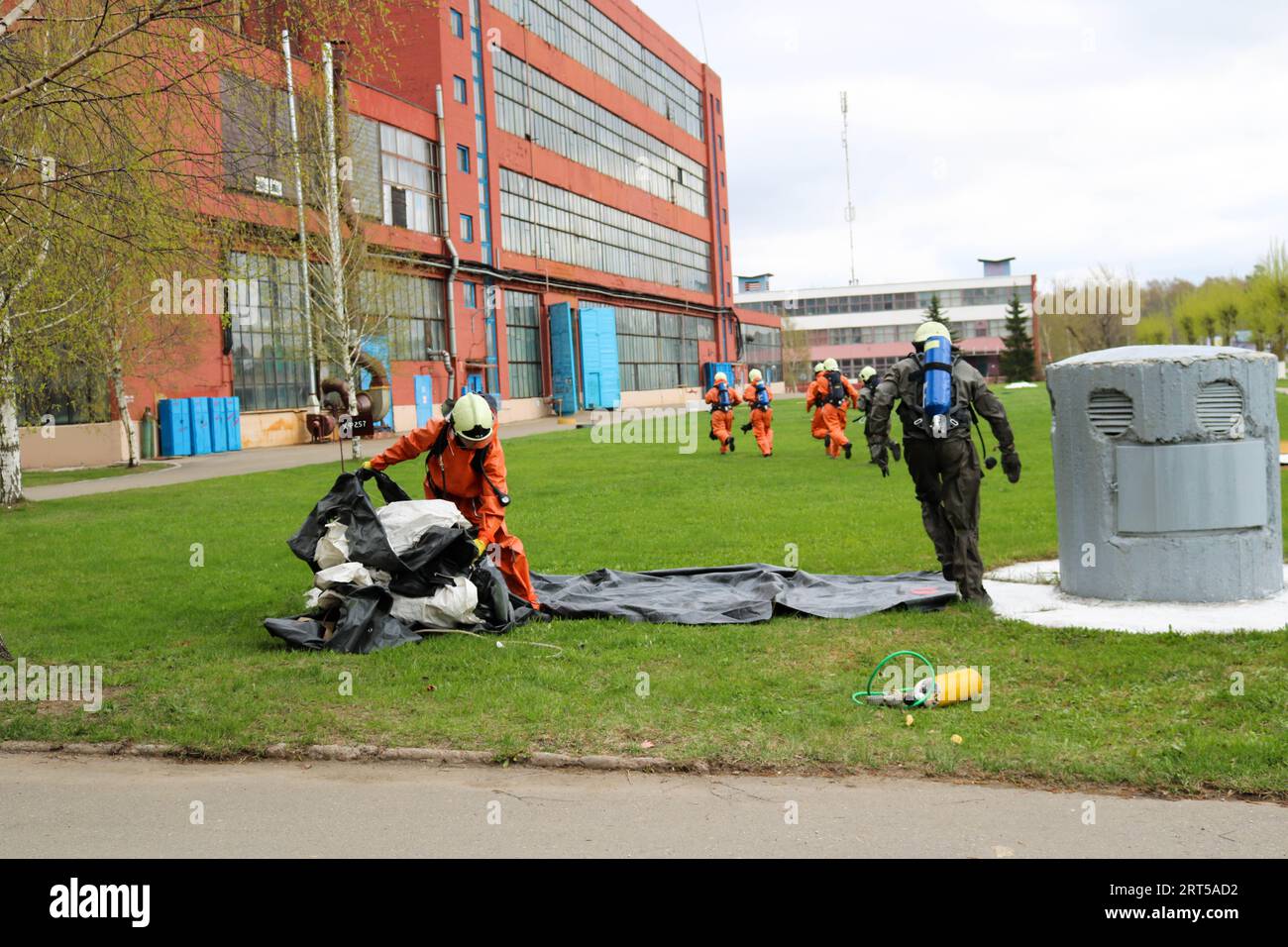 Professional firefighters, rescuers in protective fireproof suits ...