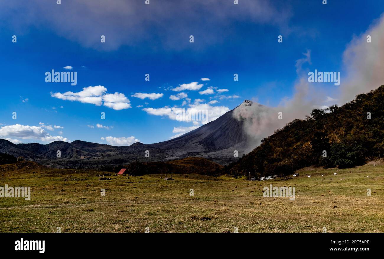 A plume of smoke billows from the active and destructive volcano at ...