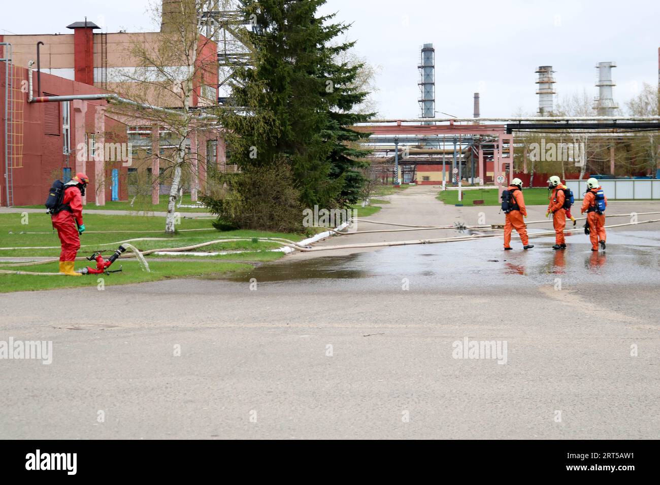 Professional firefighters in orange fire-resistant suits in white ...