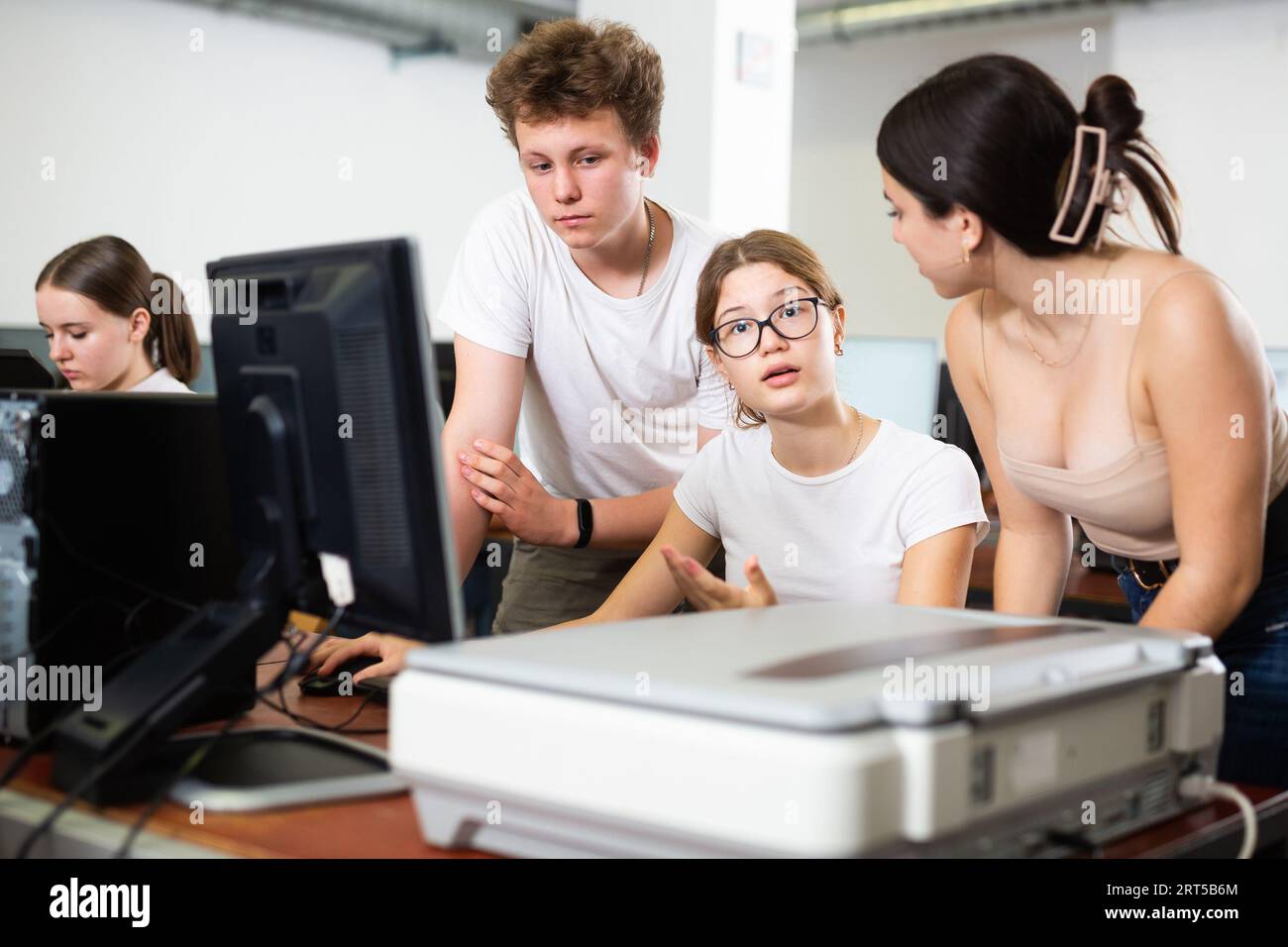Portrait of female and male students working on computers in class ...