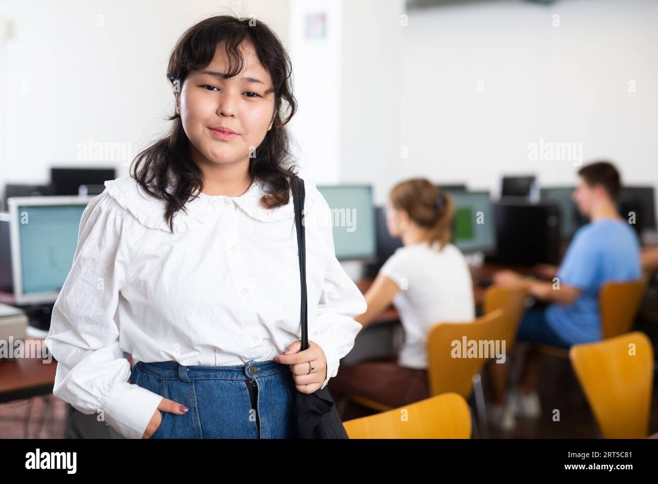 Confident interested asian female student standing in technology ...