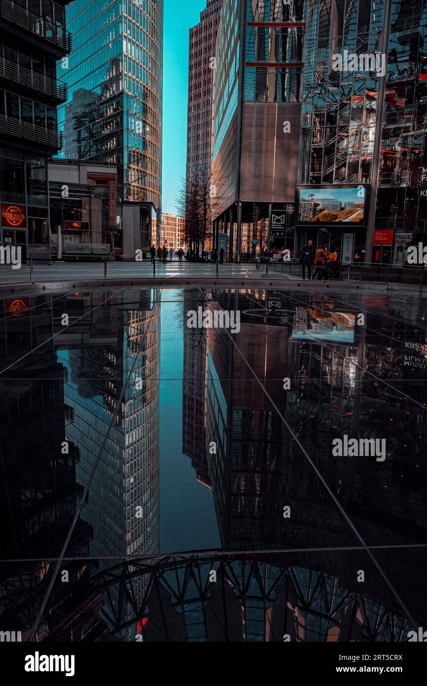 A vertical of modern buildings reflecting on the floor on the streets ...