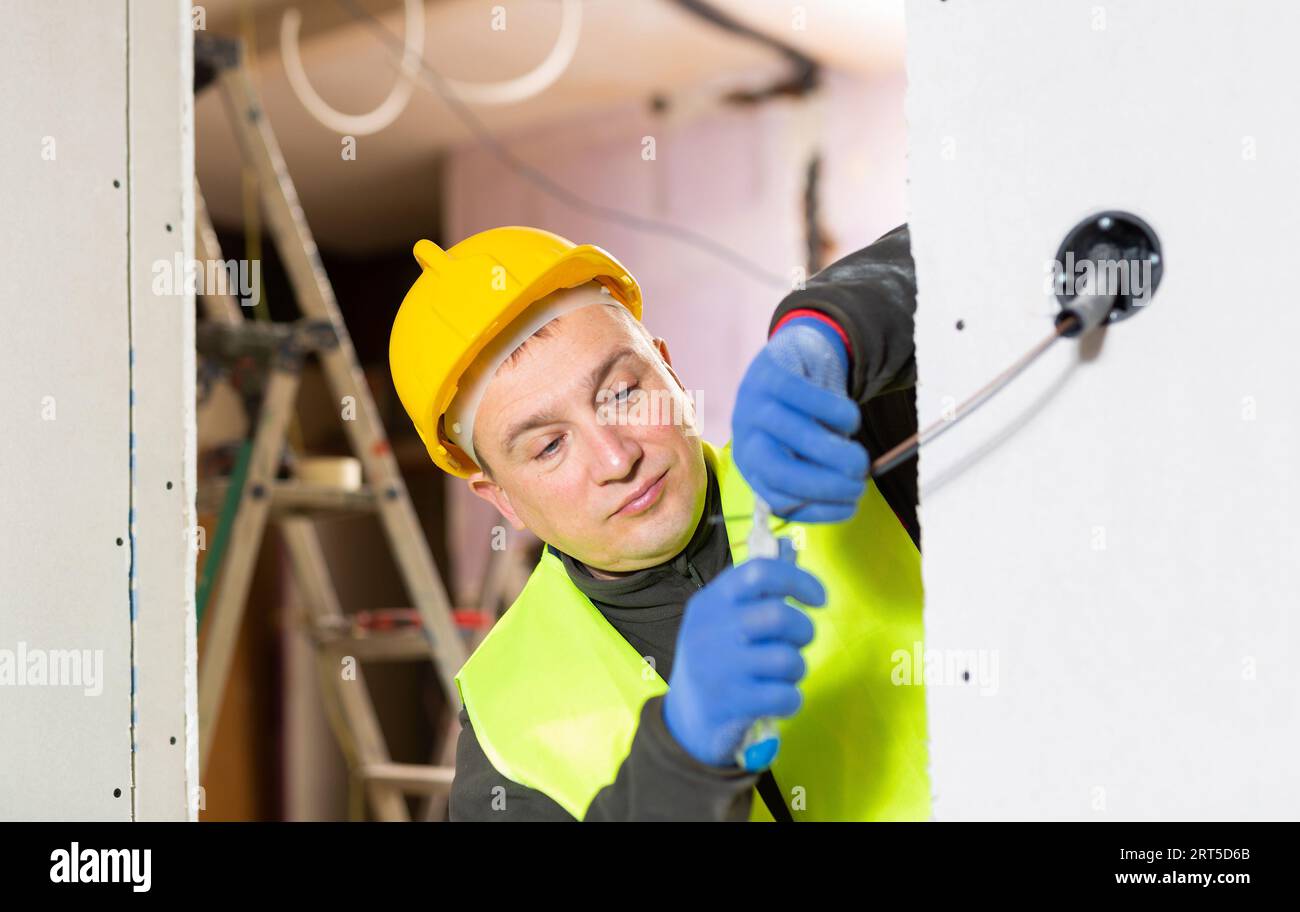Electrician installing electricity in new house Stock Photo - Alamy