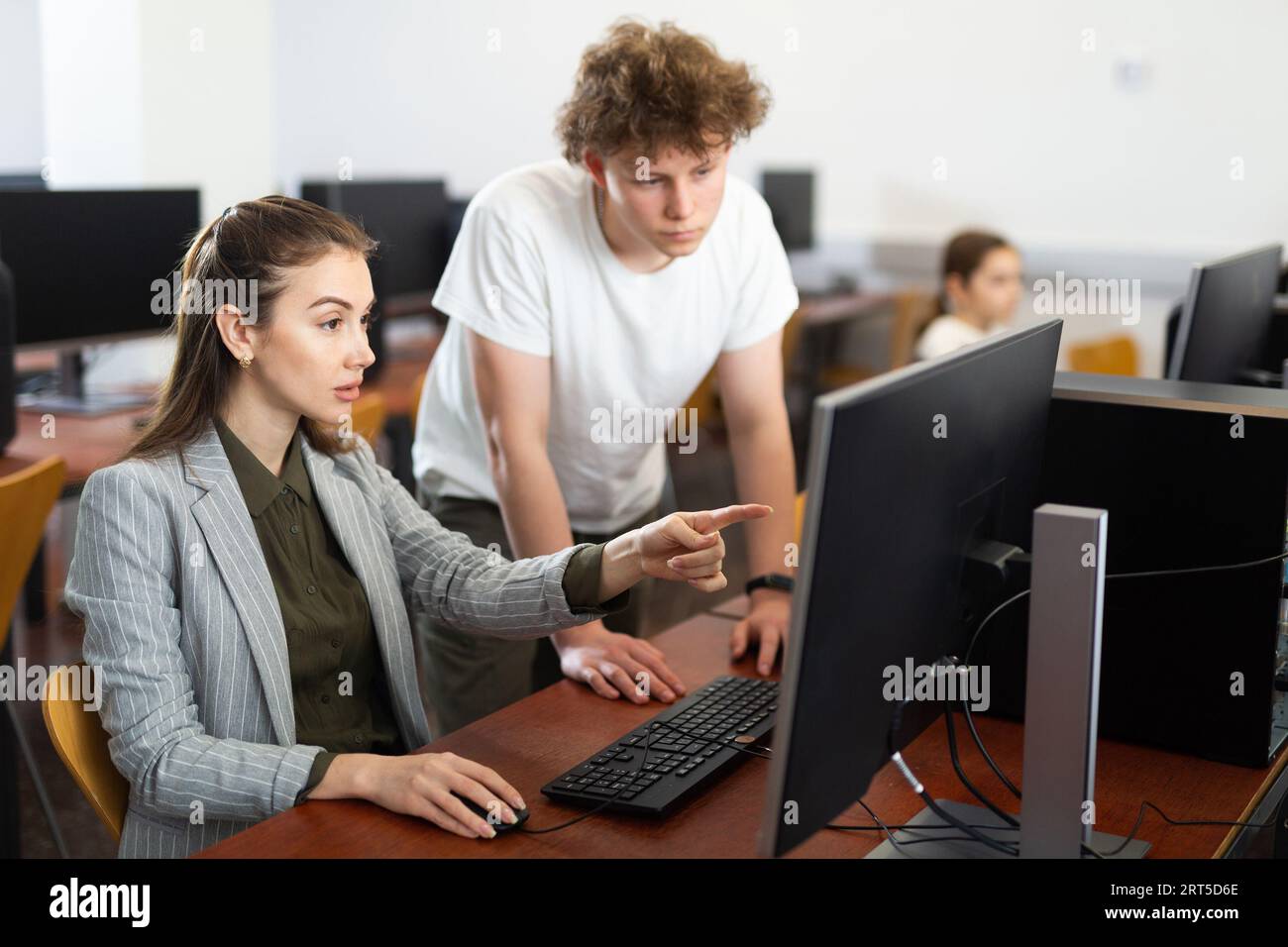 Teacher shows the student how to solve the problem on computer Stock ...