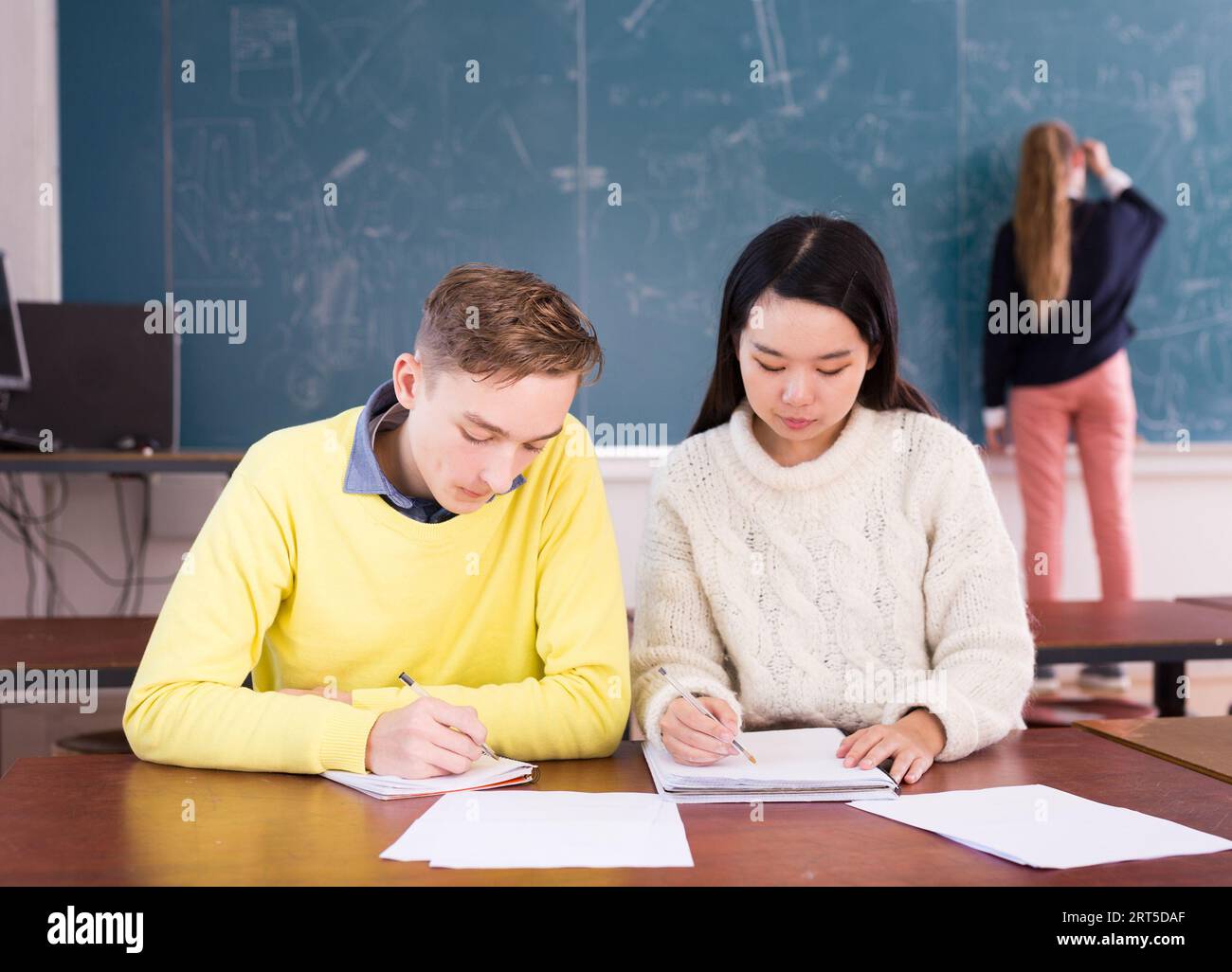Two students studying together in schoolroom Stock Photo - Alamy