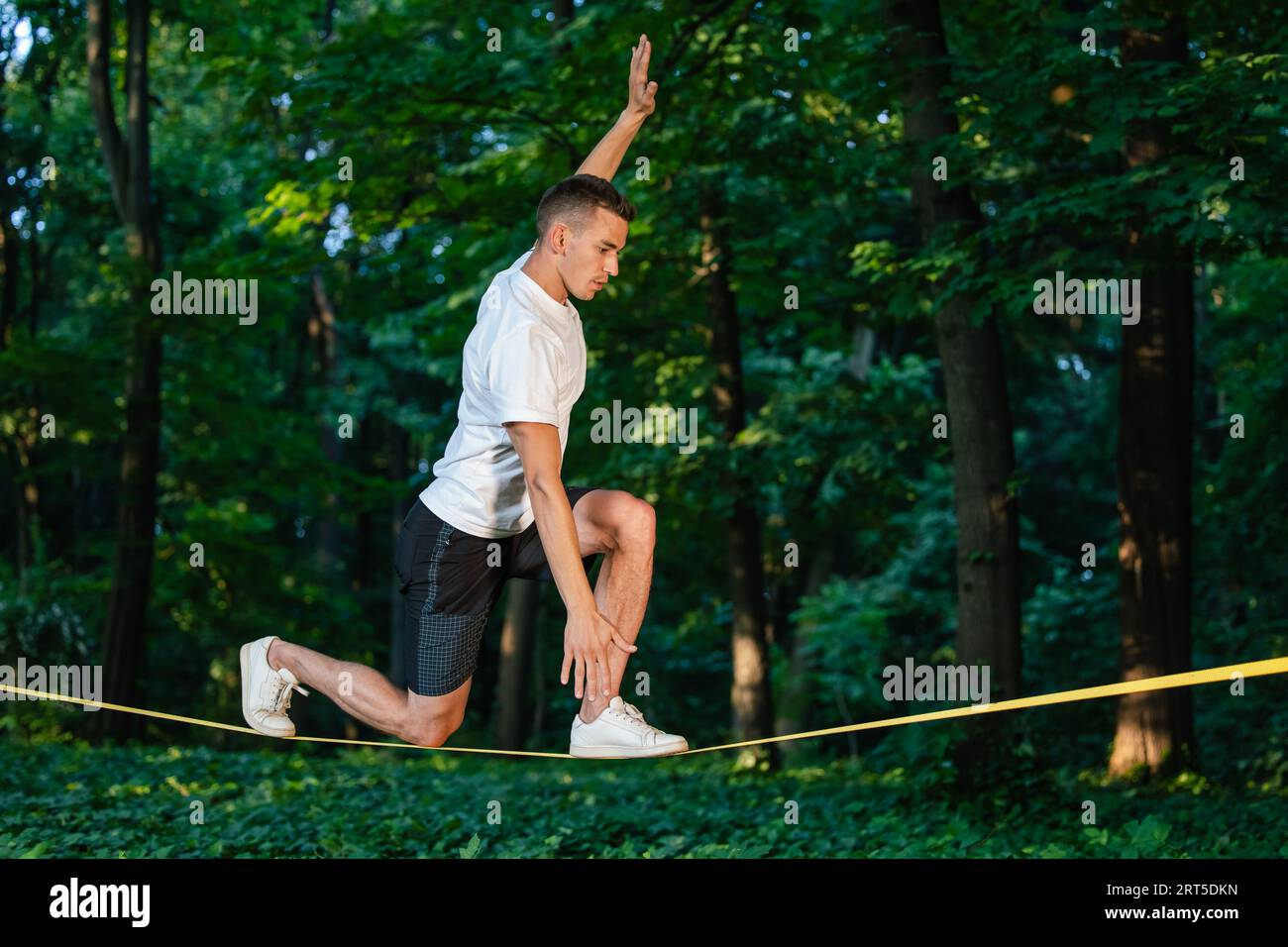 Young guy in sportwear walking on the rope and looking focused Stock ...